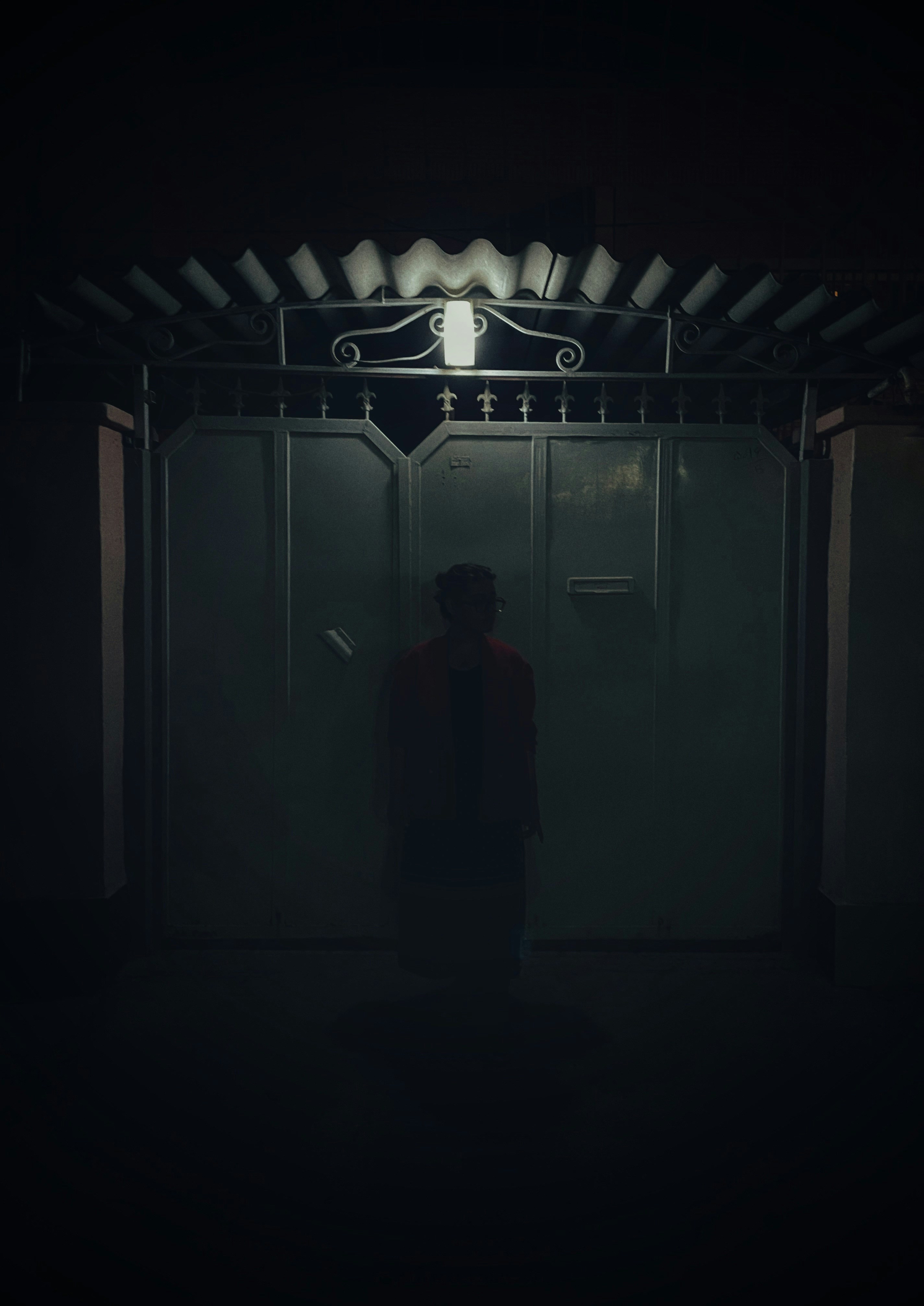 A person standing in a dark room with a light on photo – Free Girl ...