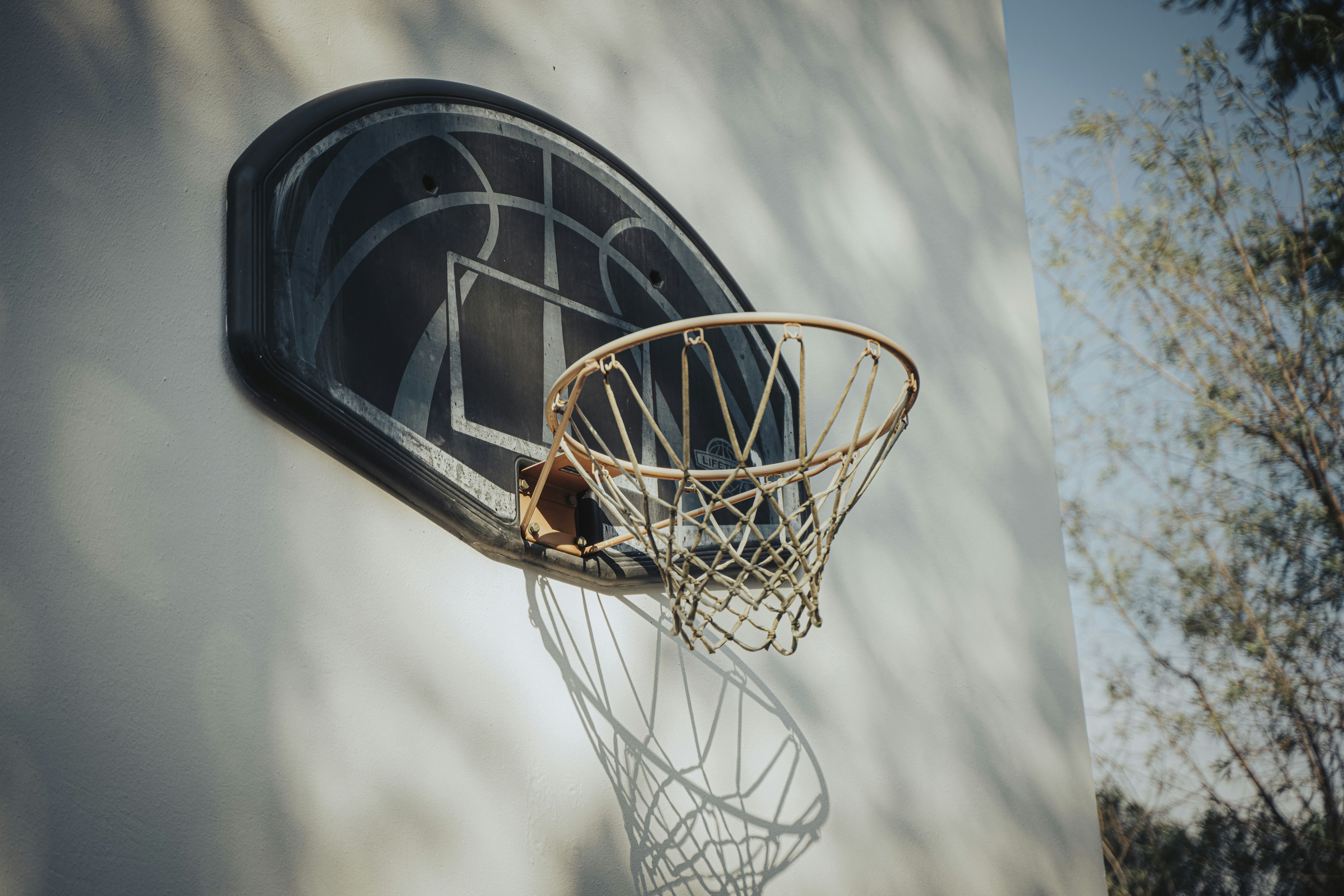 A basketball going through the rim of a basketball hoop photo – Free ...