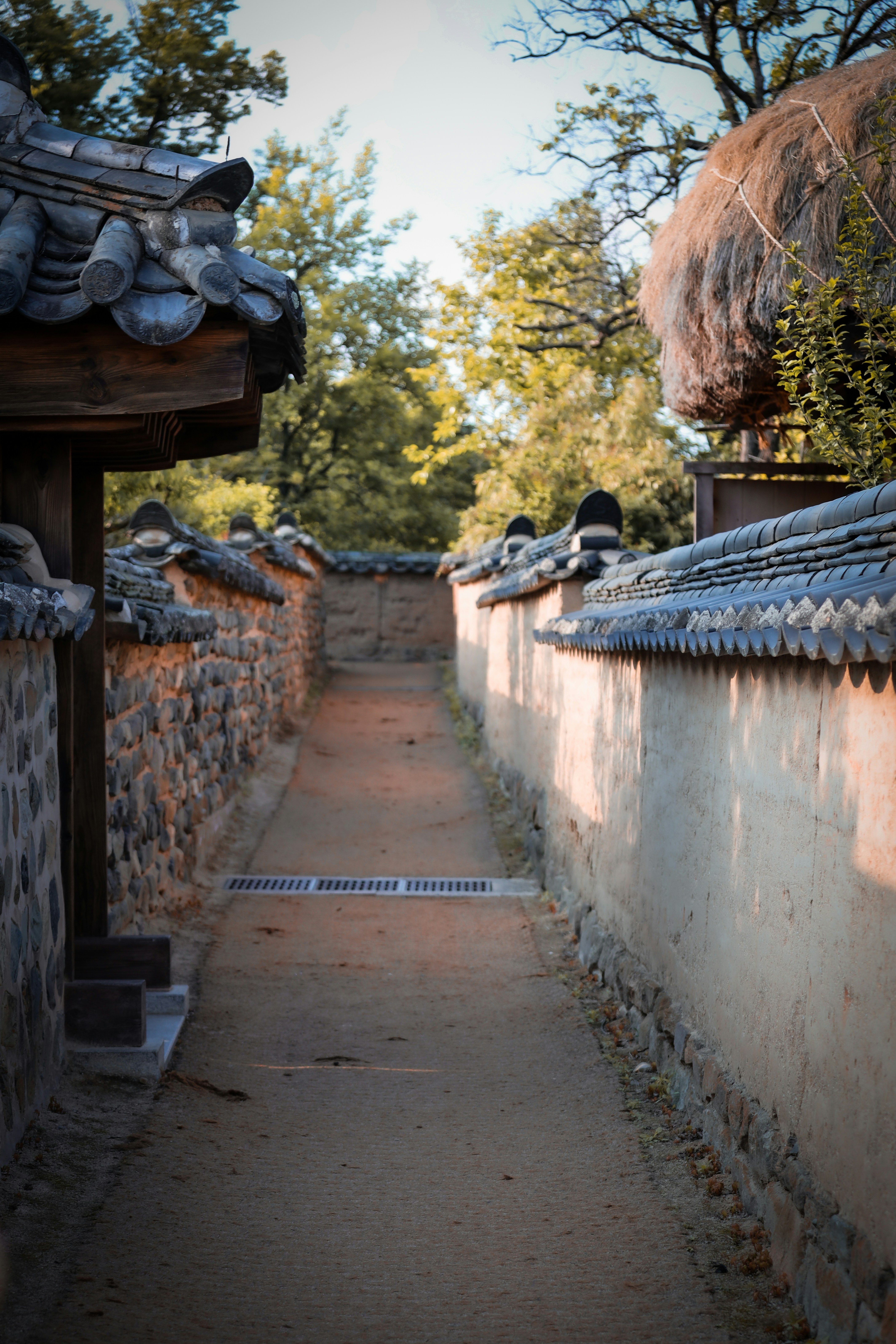 A path between two buildings with a stone wall photo – Free Alleyway ...