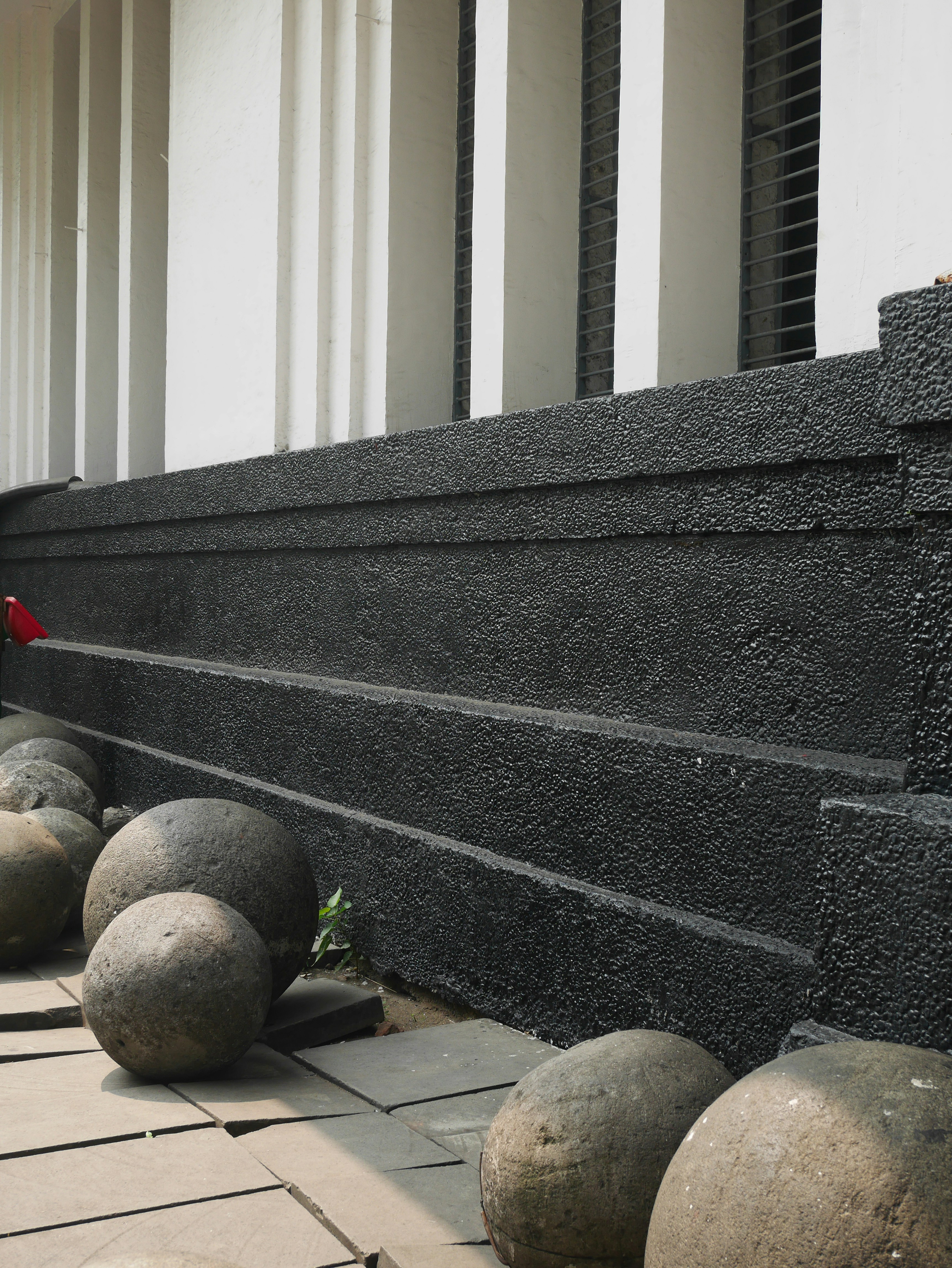 Stone Orbs at the Foot of a Modern Facade