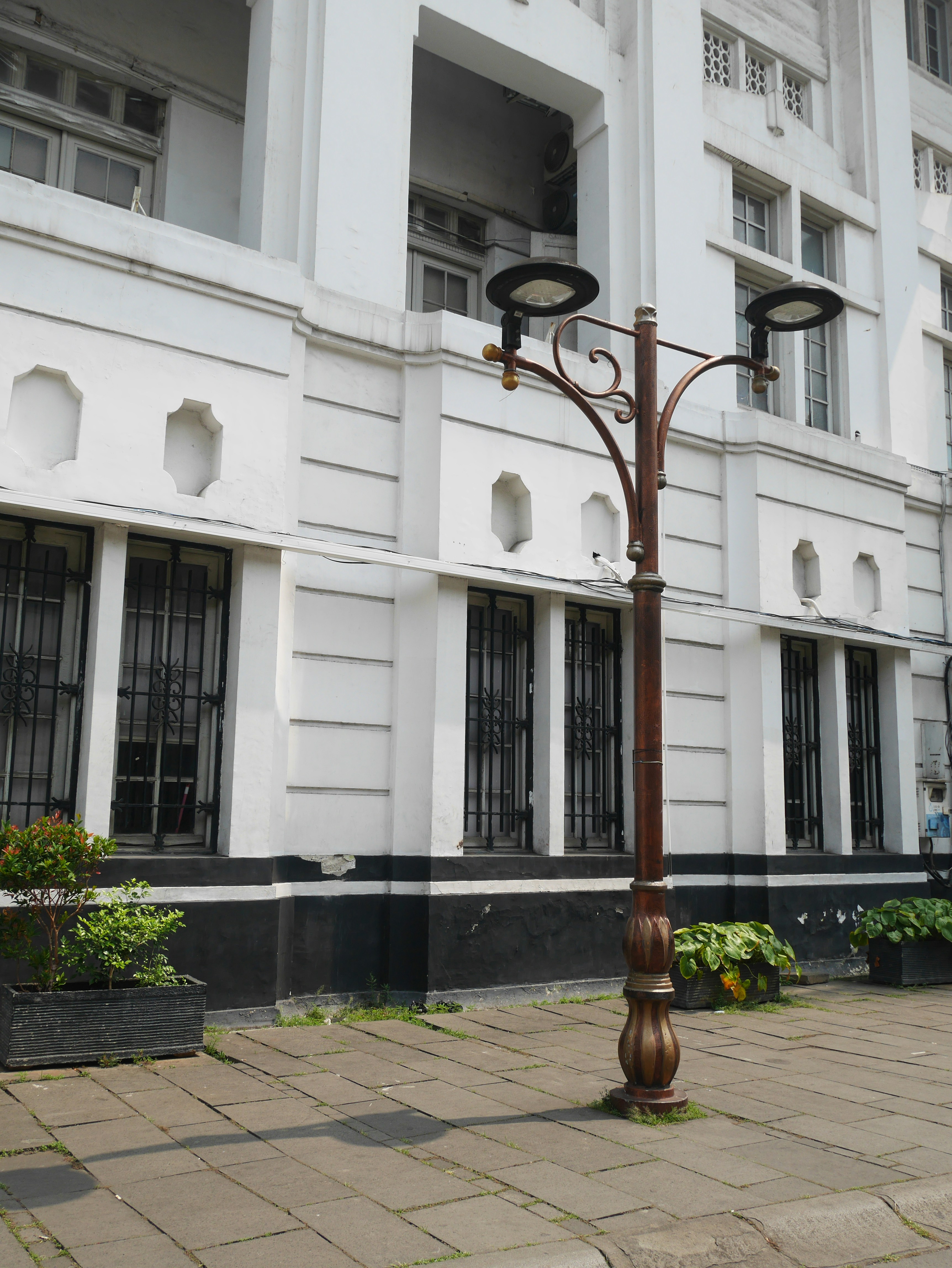 Ornate Street Lamp Anchors a Quiet White Neoclassical Facade
