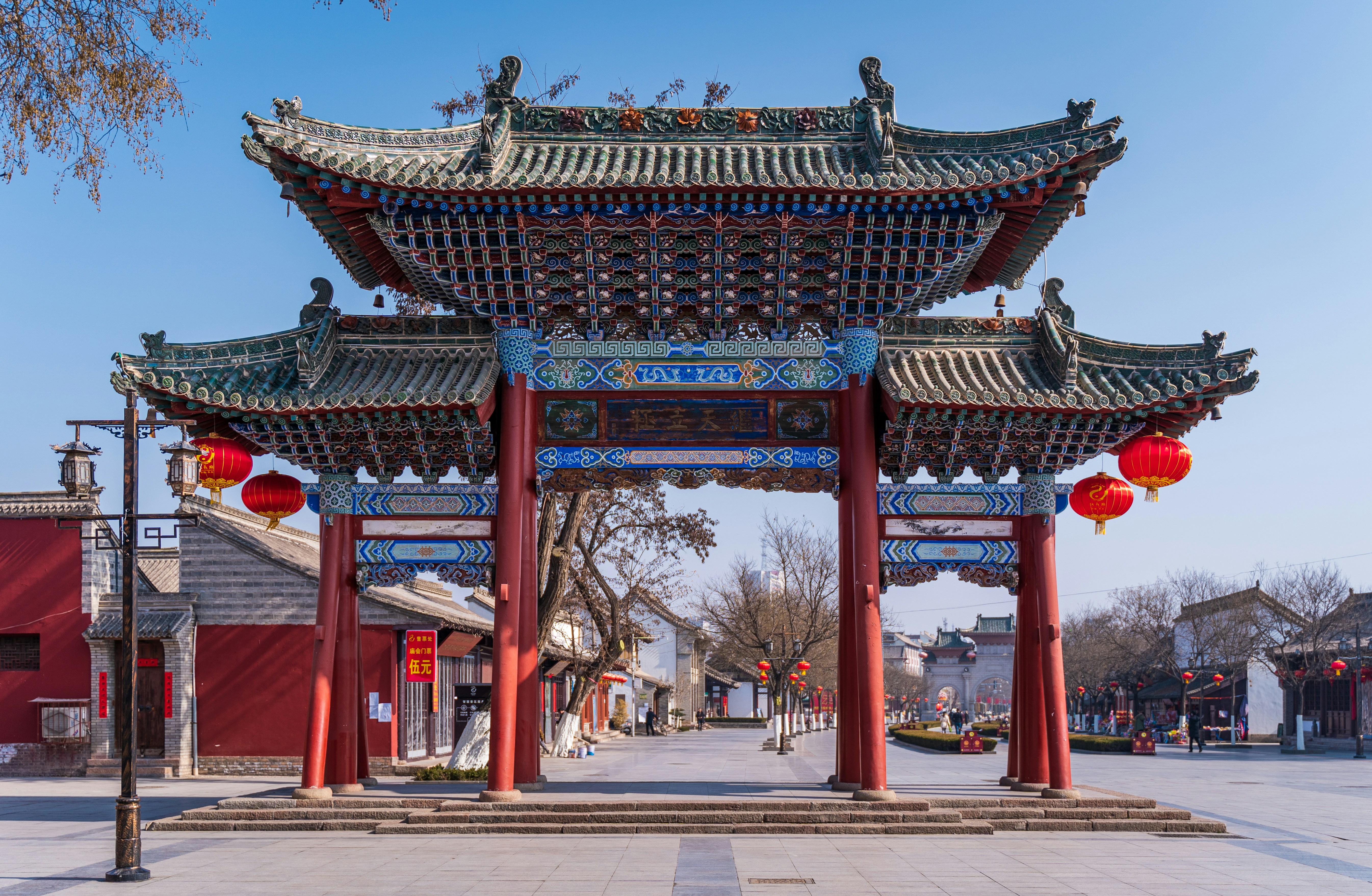The Gate of Lanterns: A Red-Columned Chinese Arch Framing a Quiet Street