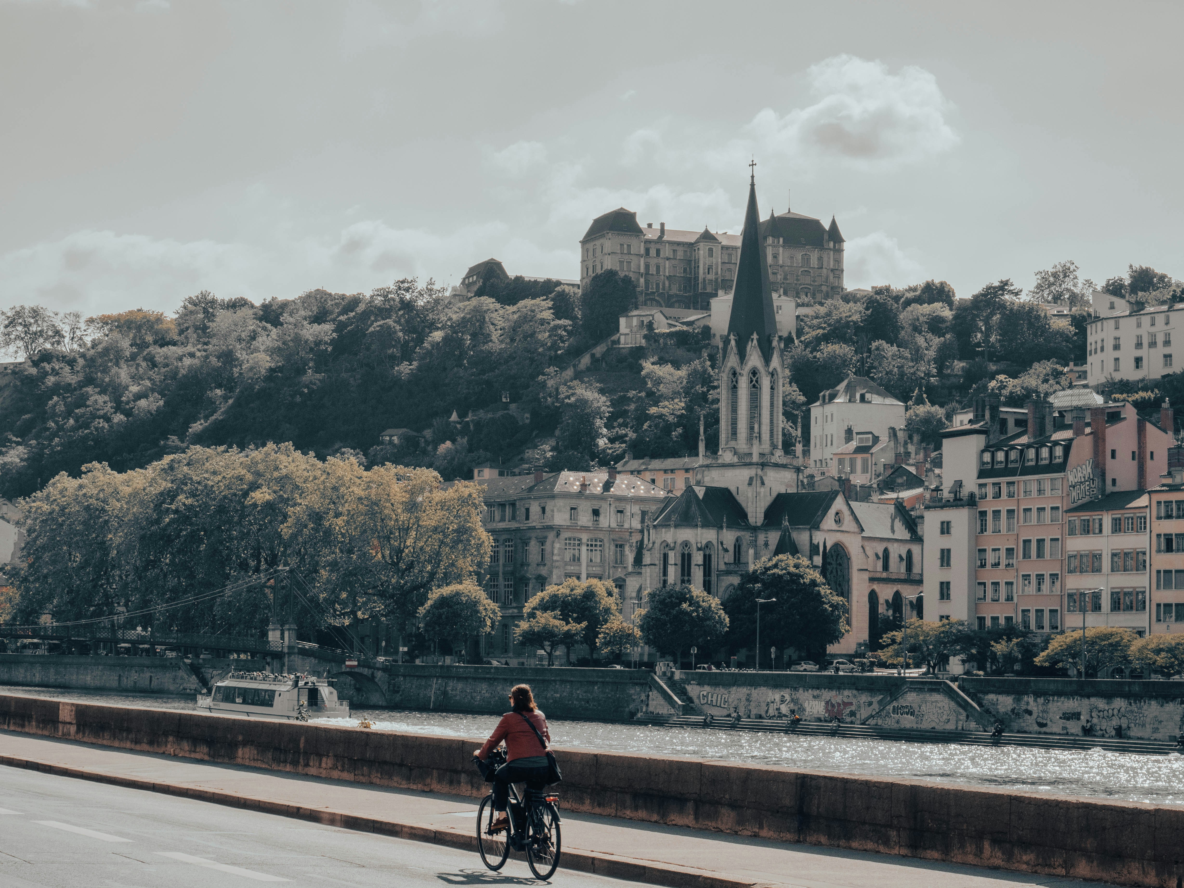 a person riding a bike on a bridge over a river