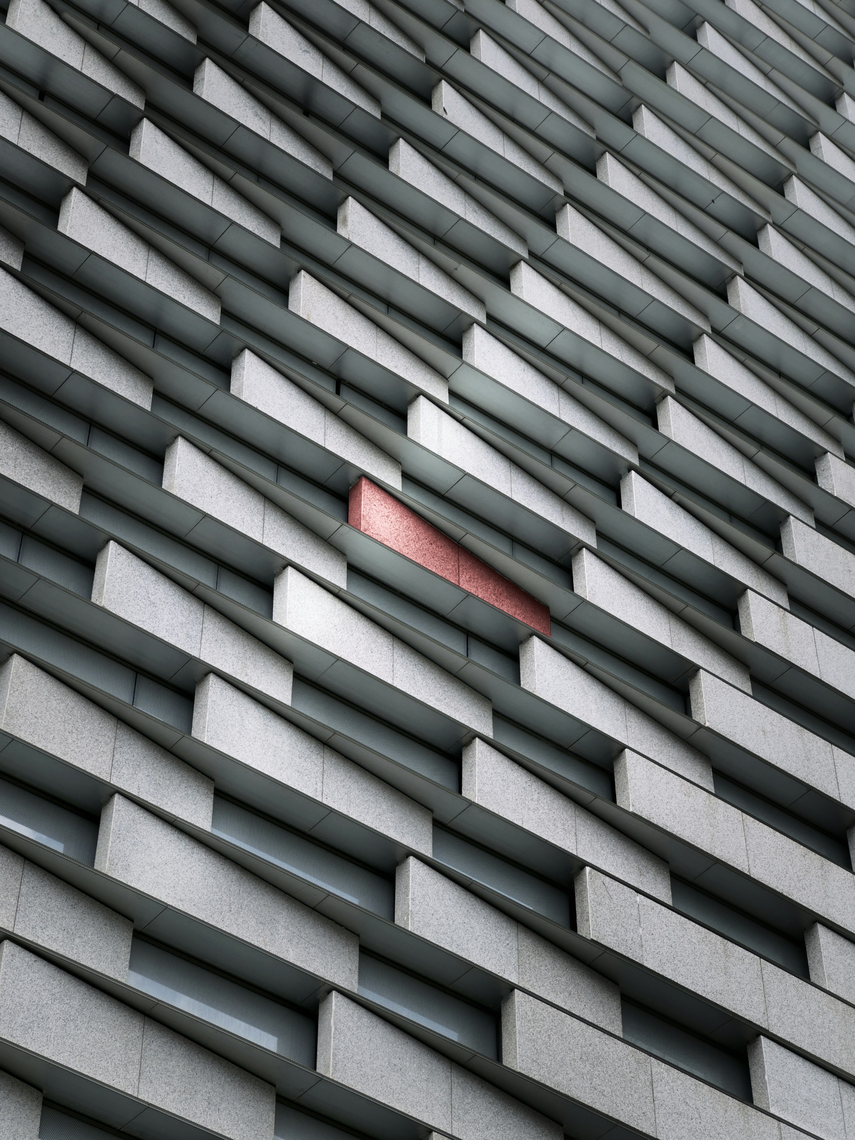A red object is sticking out of the side of a building photo – Free ...