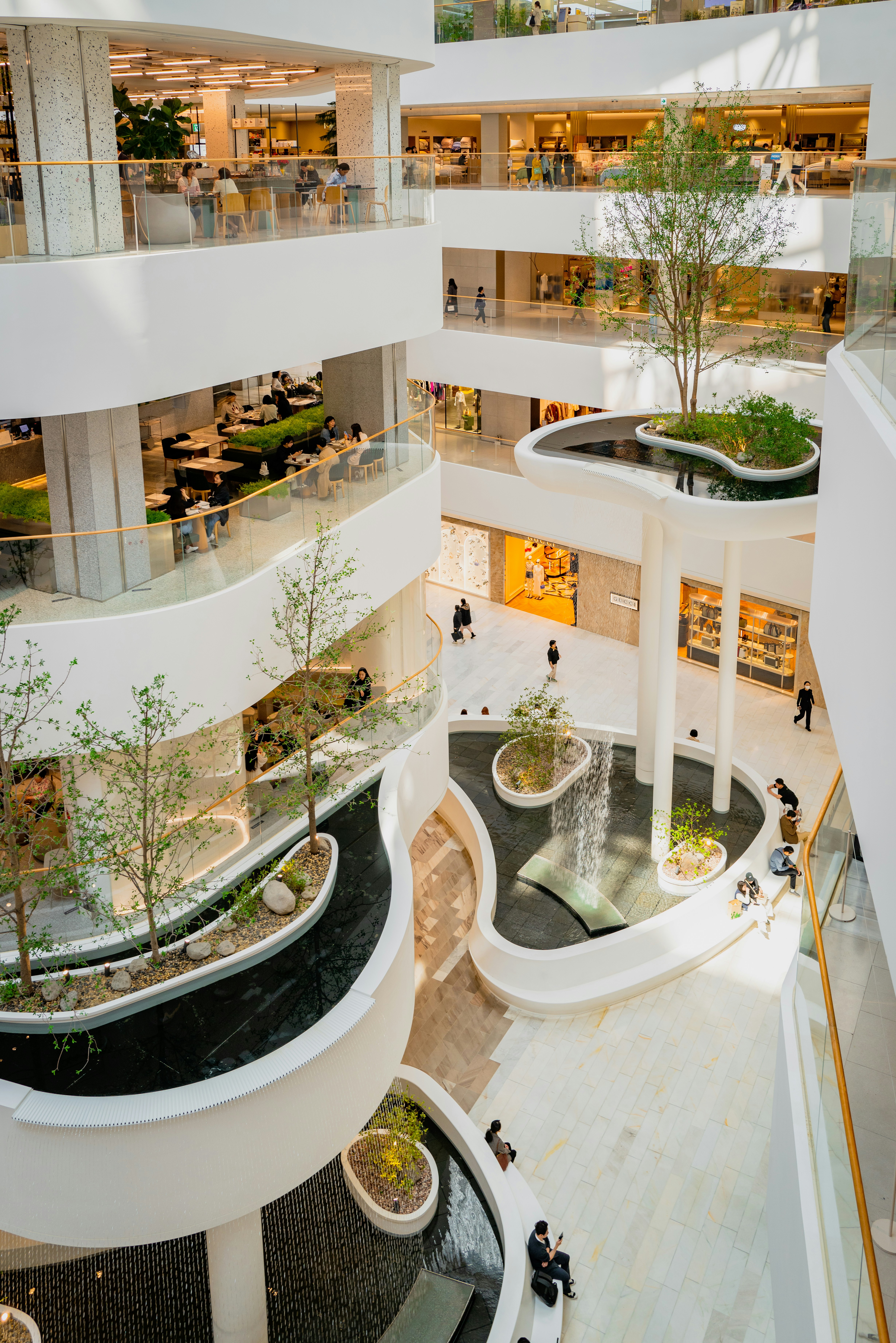 A group of people walking around inside of a building photo – Free ...