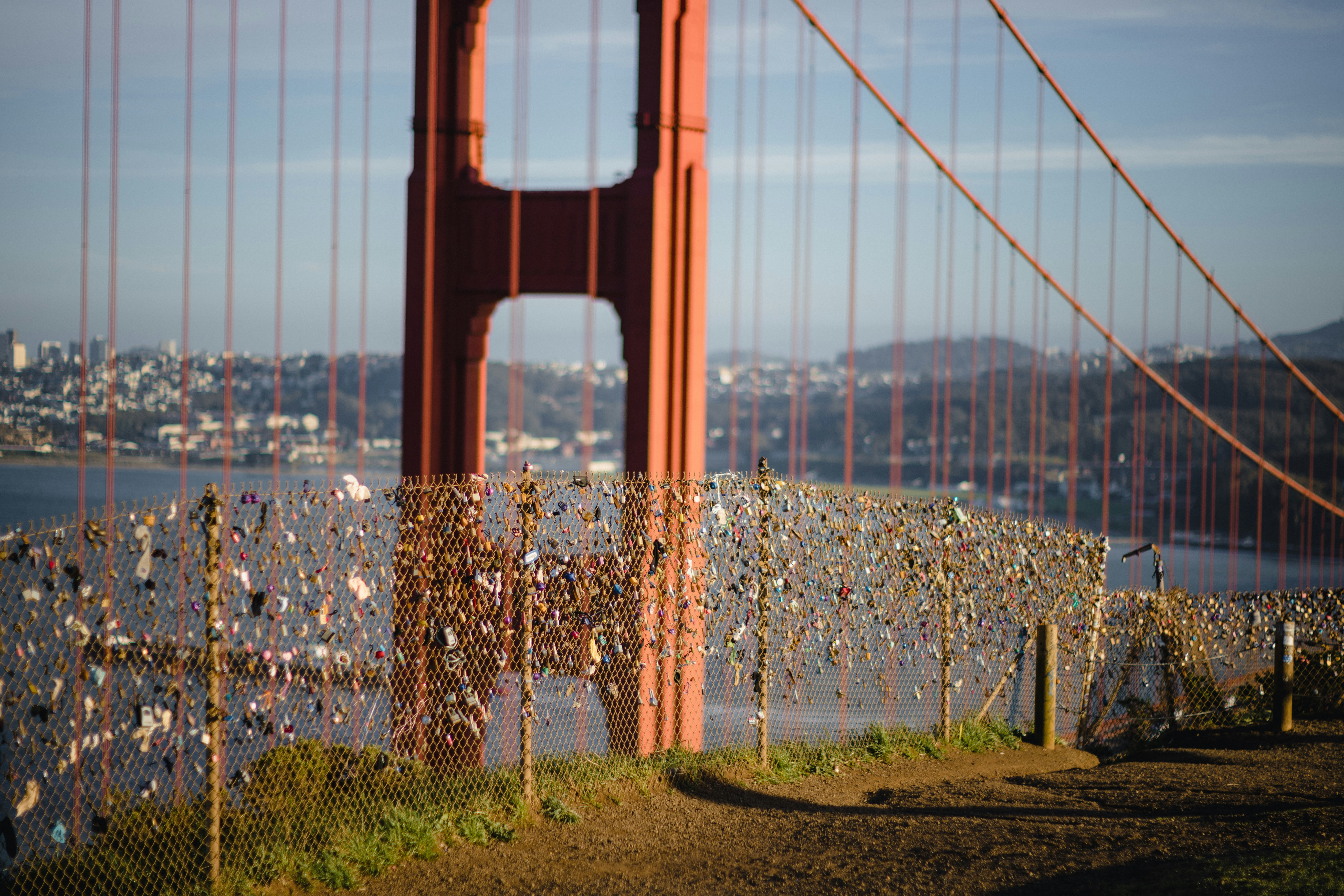 Red Arch Over the Fence: The Golden Gate Framed by a Weathered Barrier