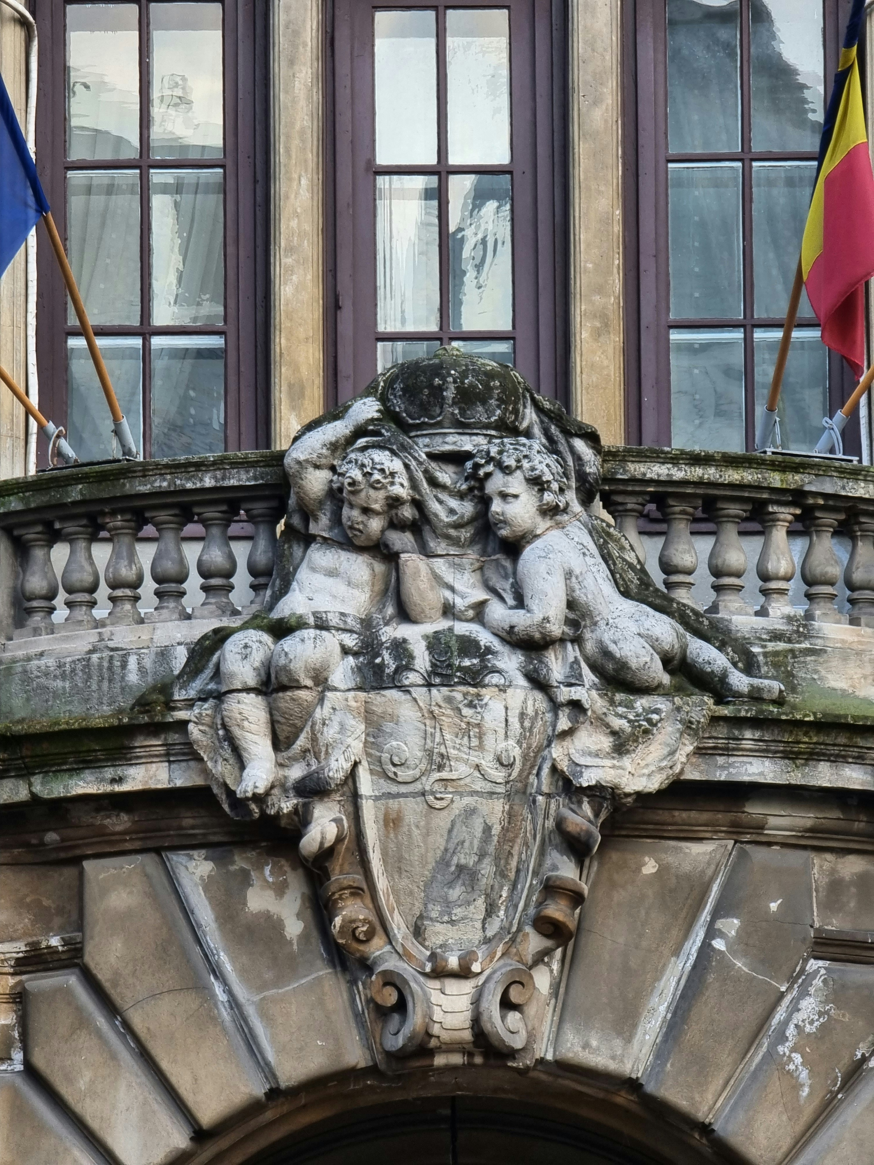 Cherubs at the Crest: Weathered Stone Adorning a Majestic Facade