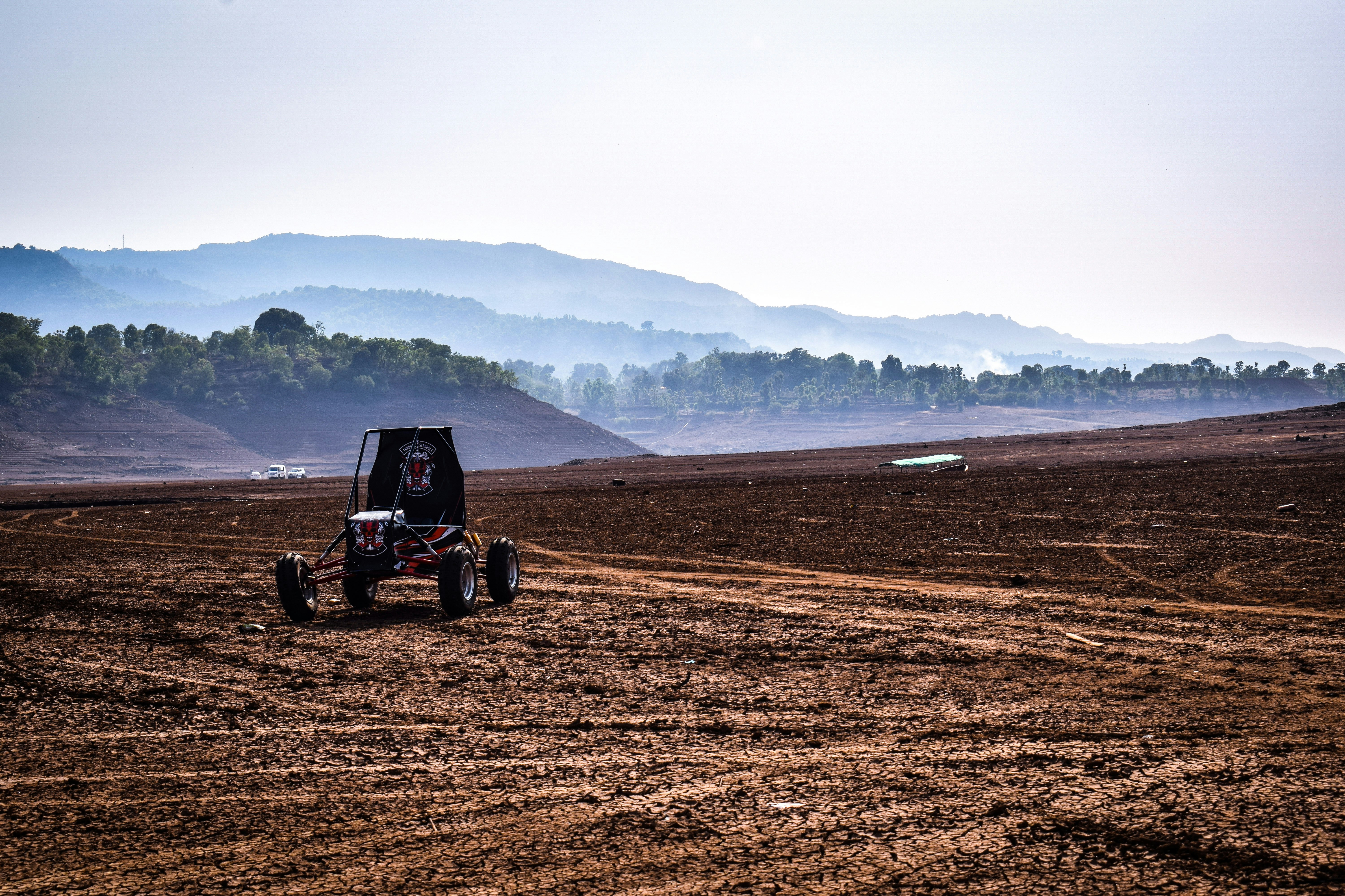 A buggy driving on a dirt road in the middle of a field photo – Free ...