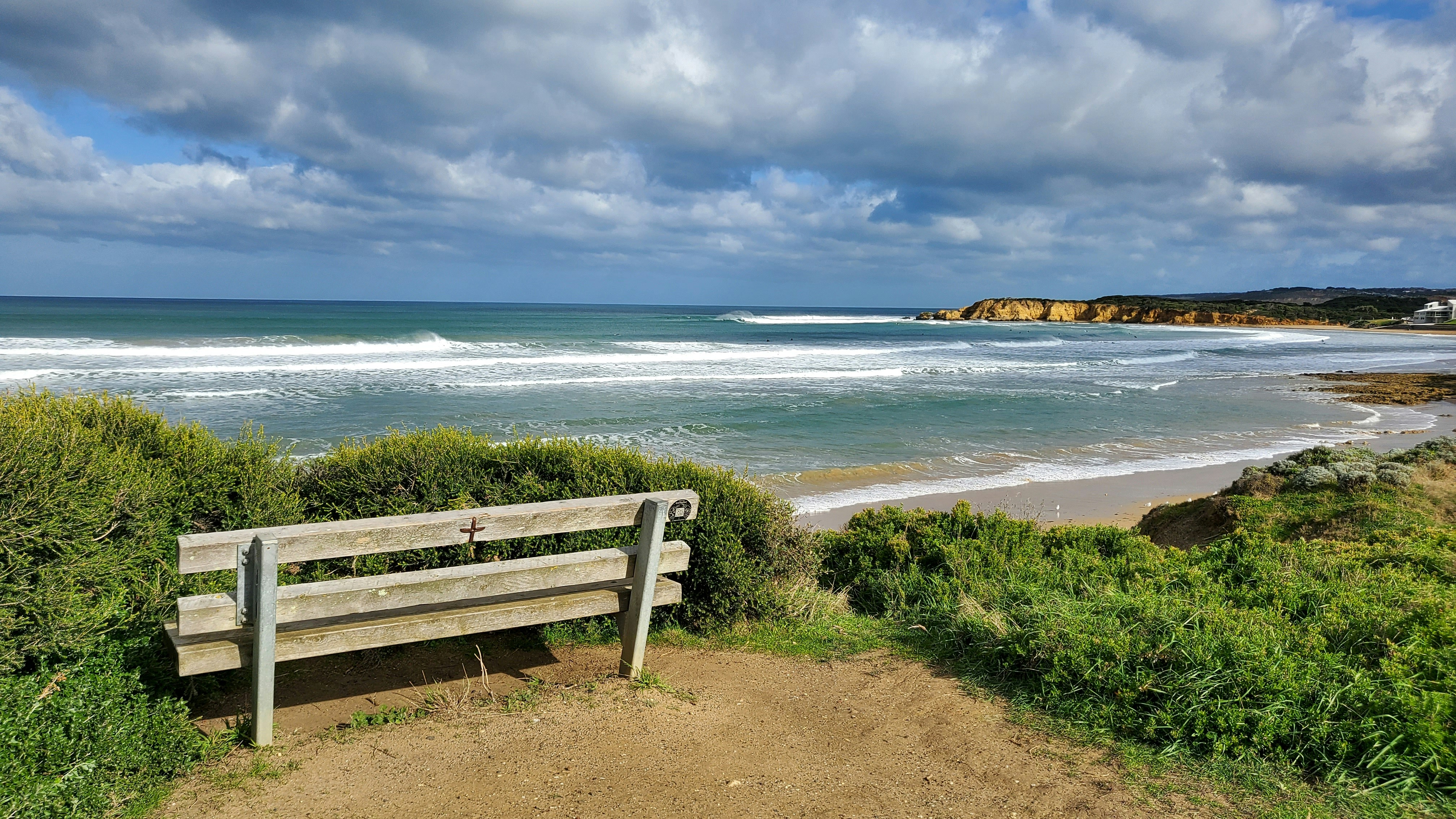 A wooden bench sitting on top of a sandy beach photo – Free Bells beach ...