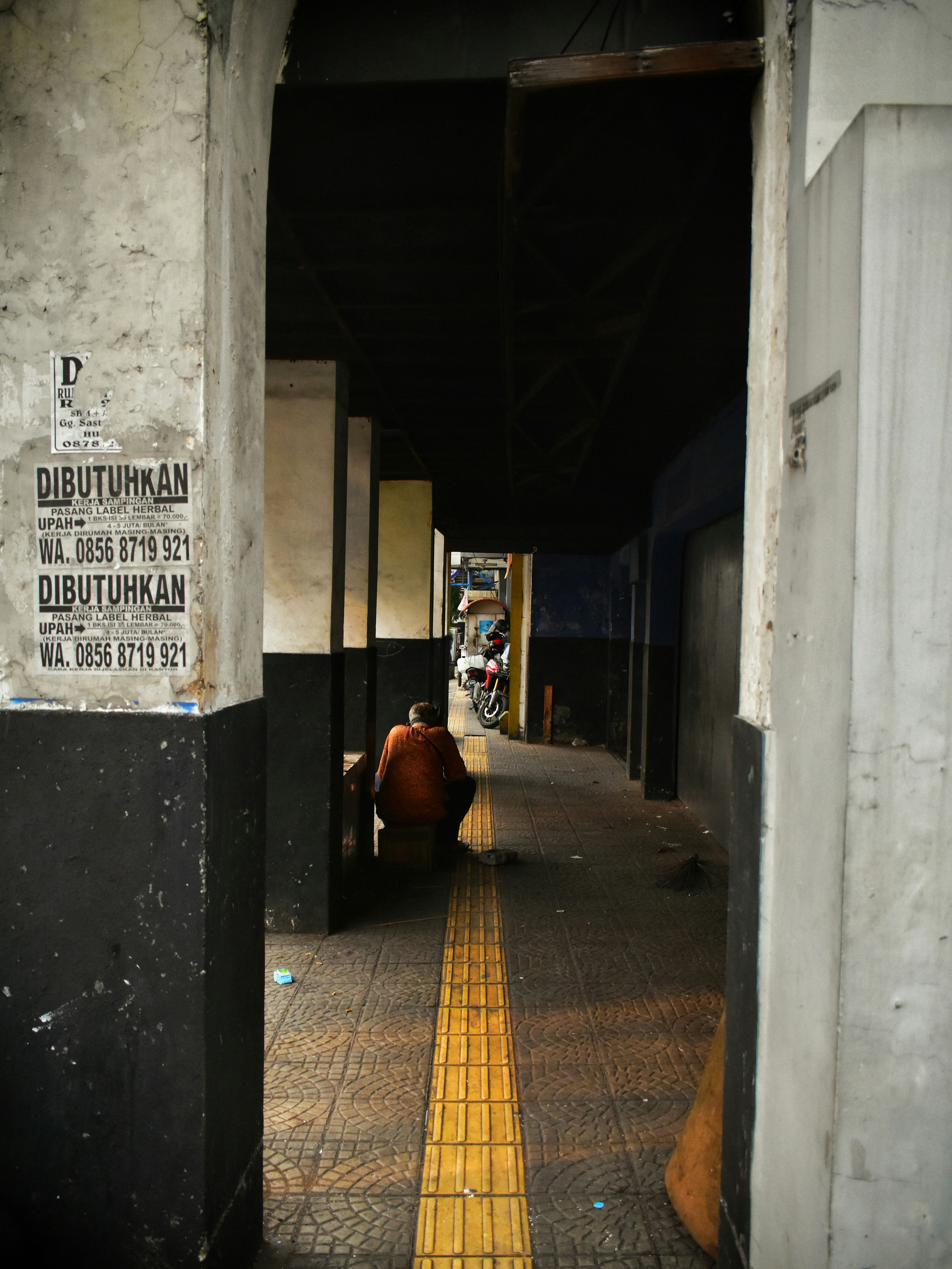 A person sitting on a bench on a sidewalk photo – Free City Image on ...