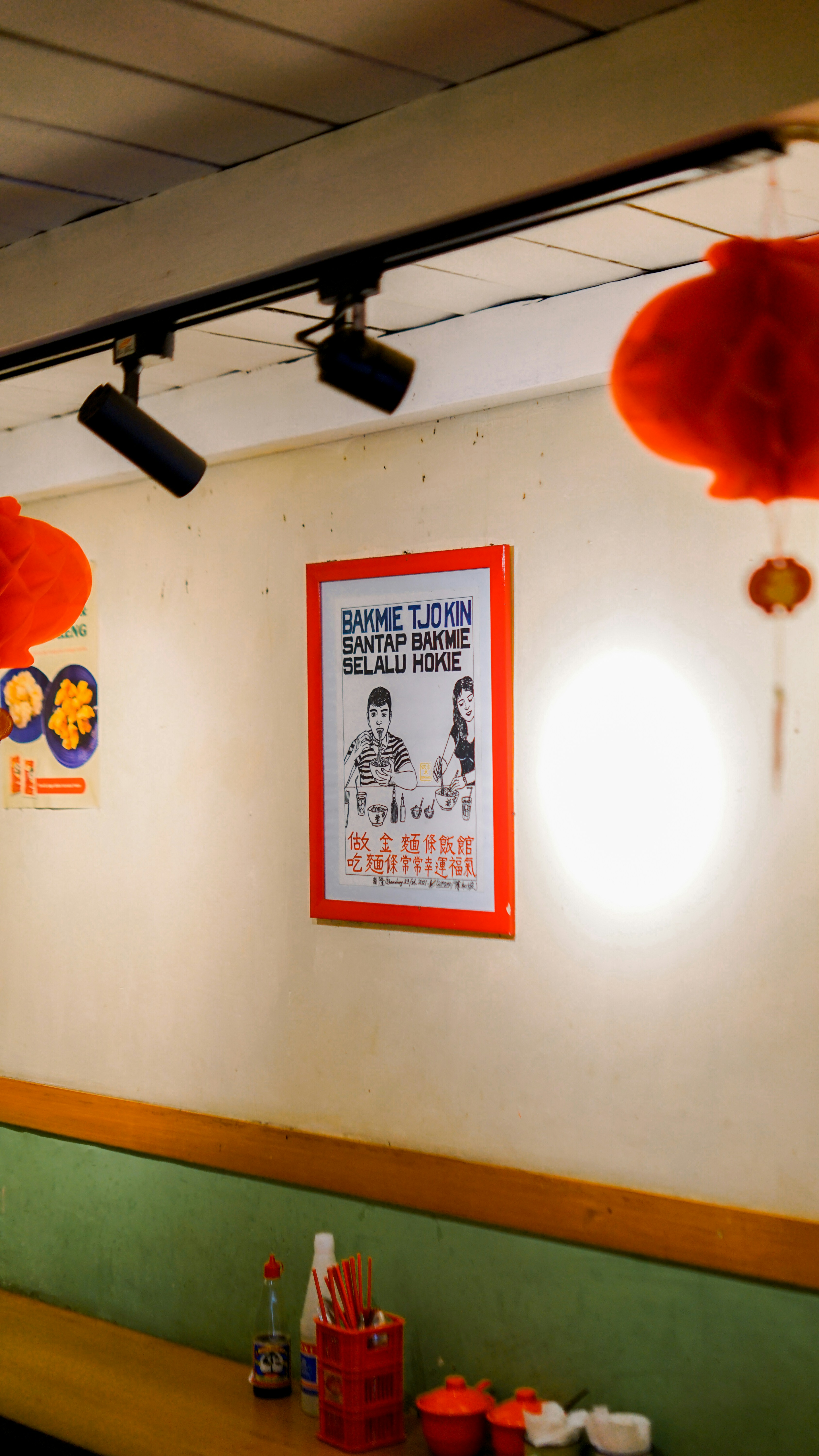 Red-Framed Cartoon Poster Anchors a Minimalist Café Wall