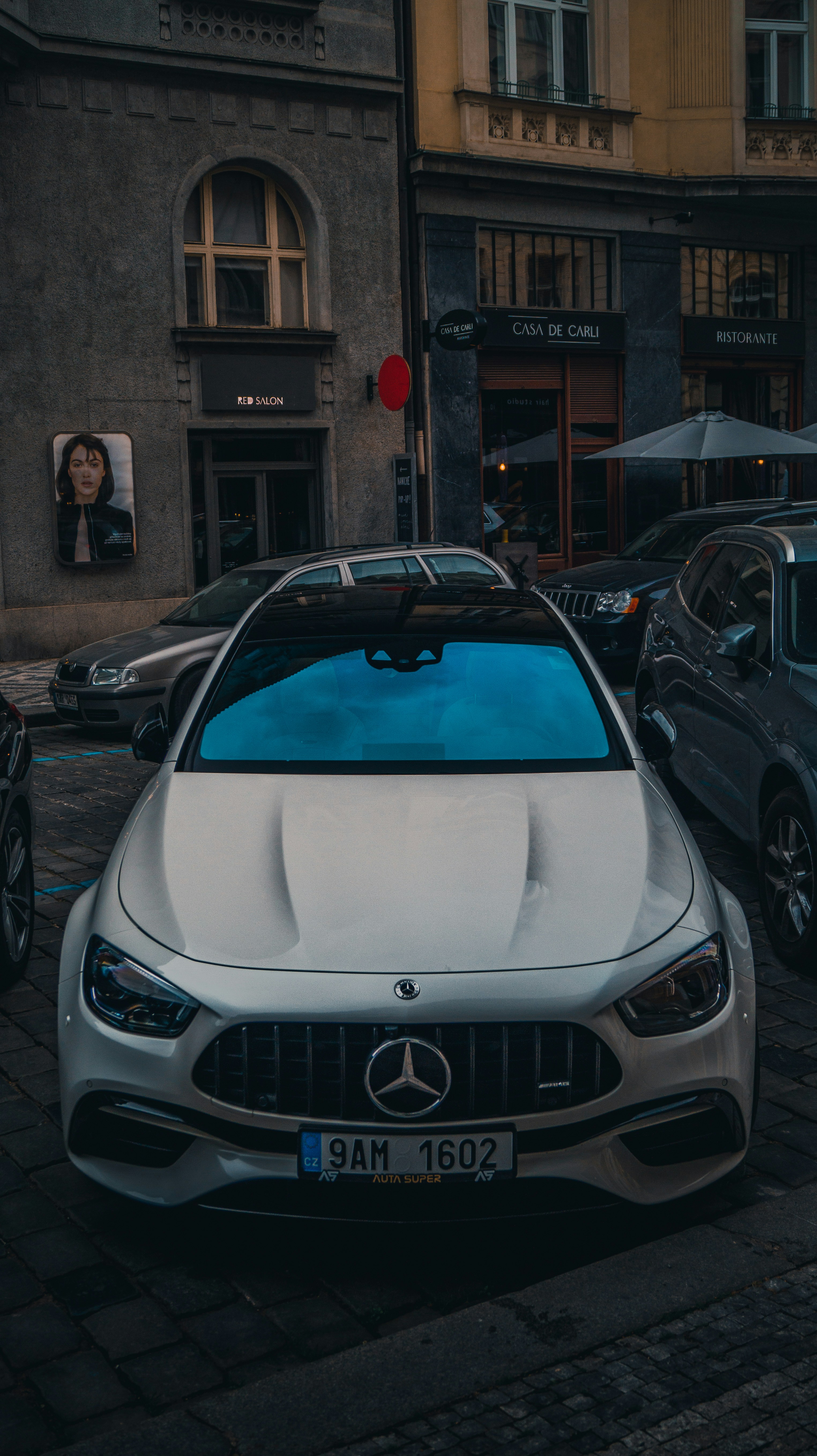 Front-Row Chrome: A White Mercedes Guards a Cobblestone Street