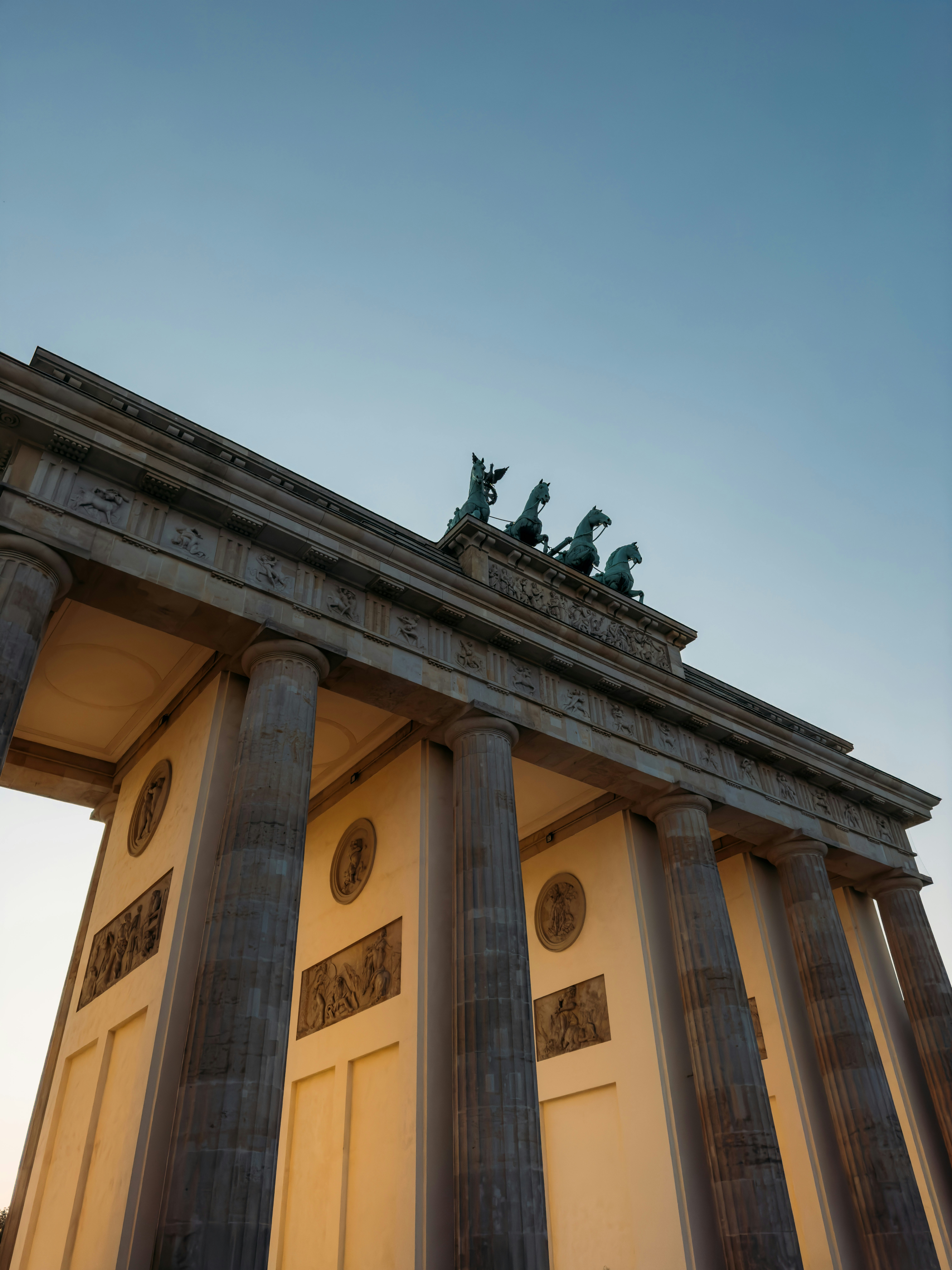 A tall building with statues on top of it photo – Free Street ...