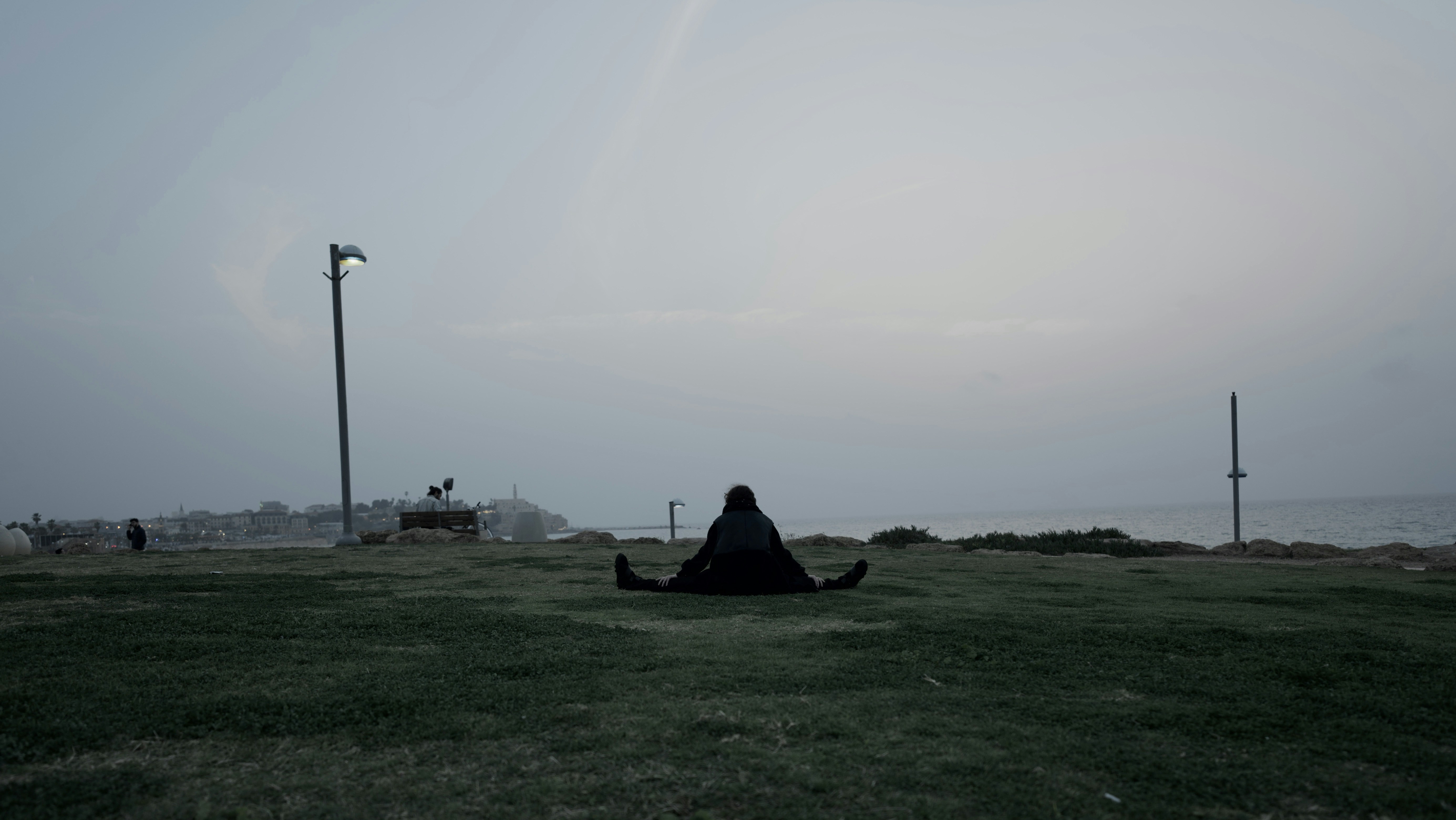 Quiet Seaside Silhouette: A lone figure gazes toward the pale horizon.