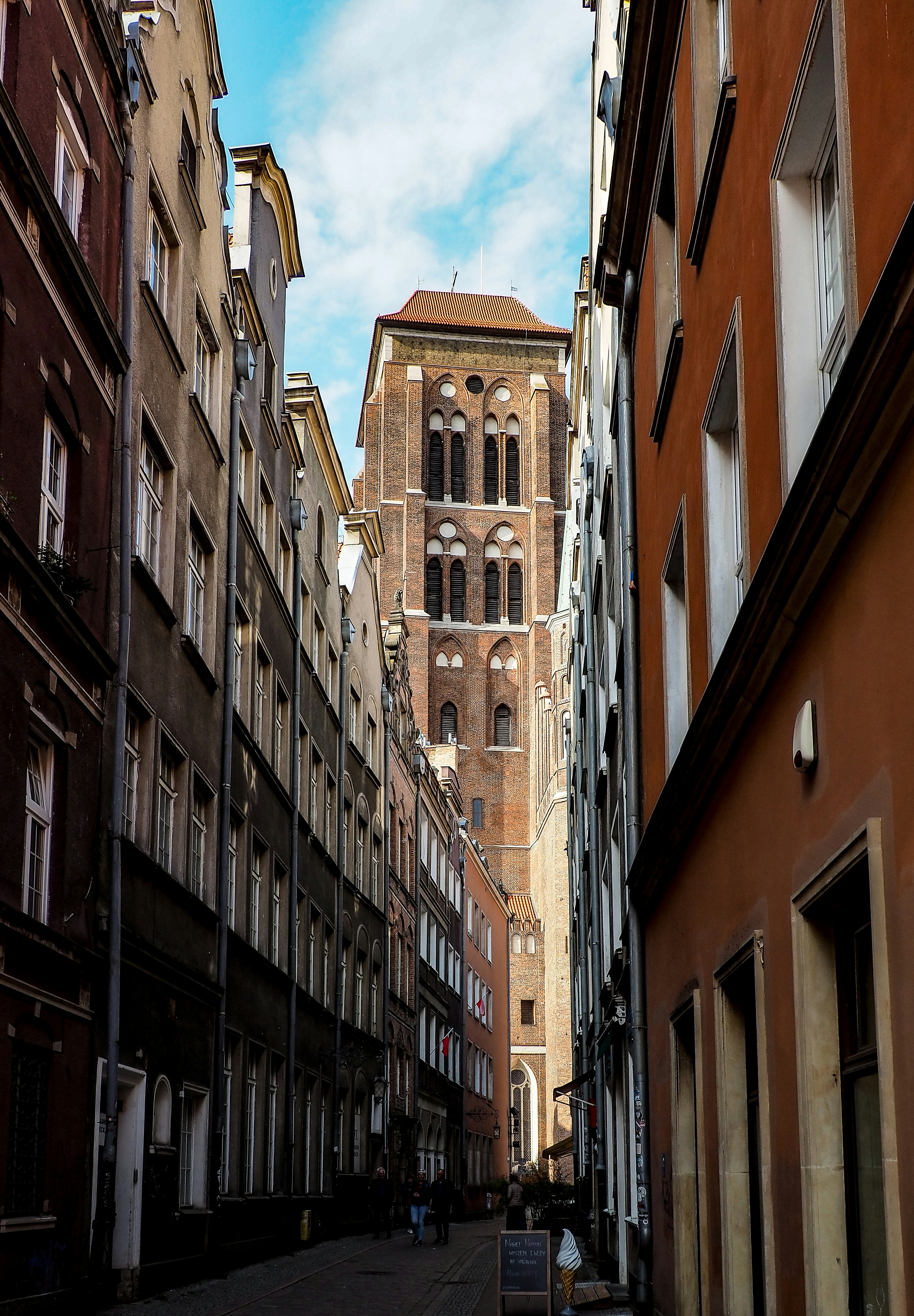 A narrow city street lined with tall buildings photo – Free Poland ...