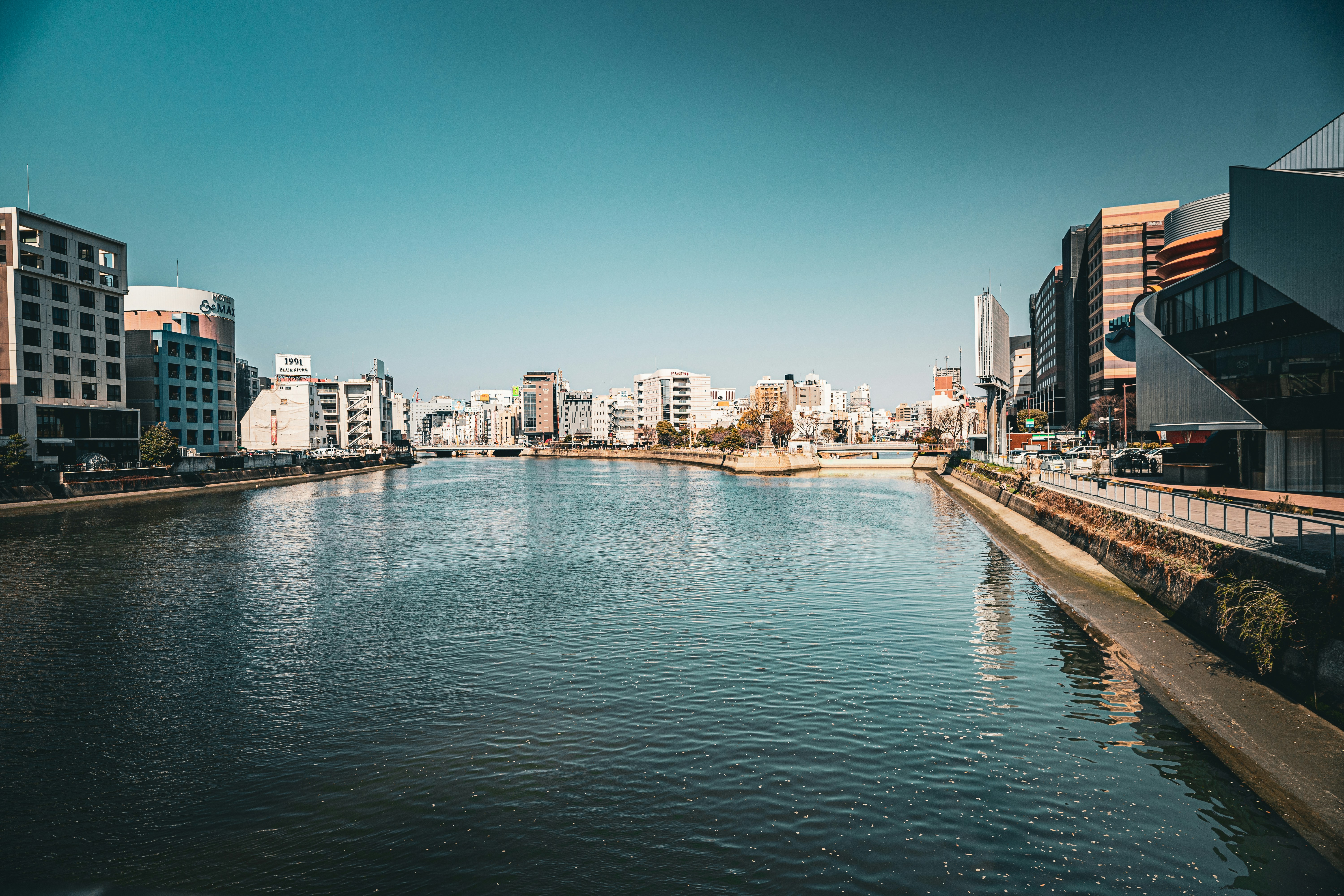 A river running through a city next to tall buildings photo – Free ...