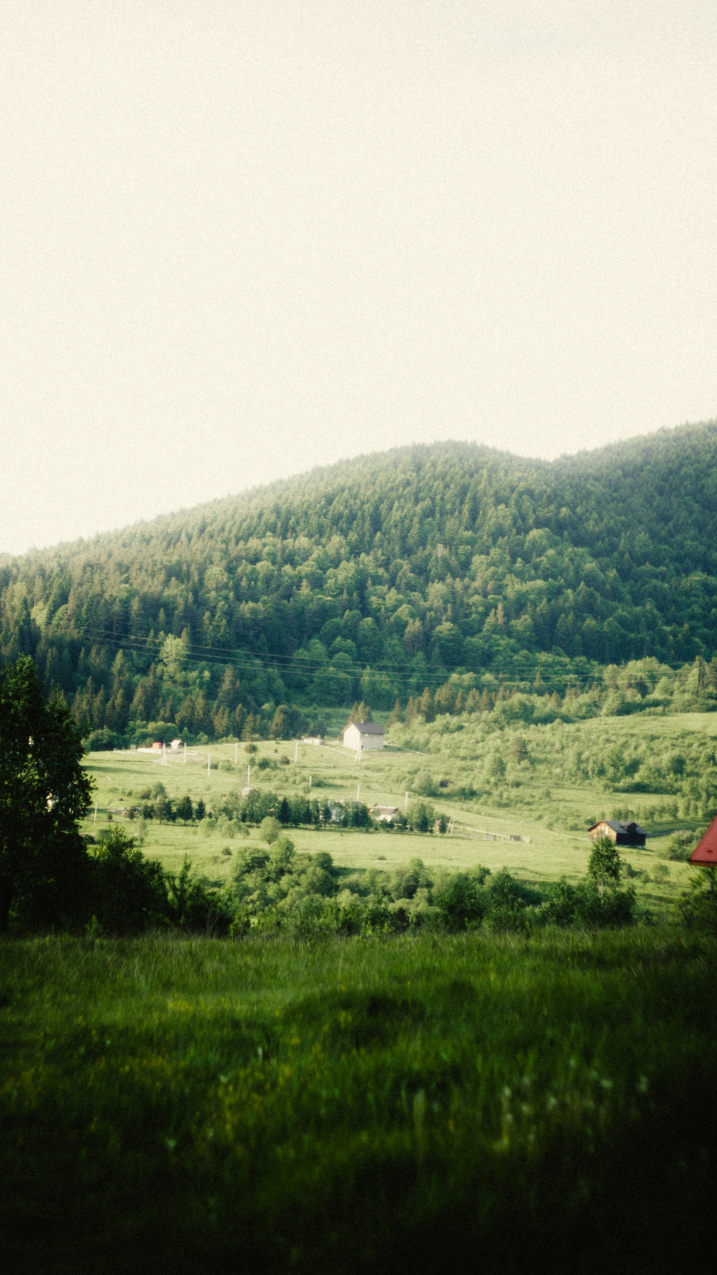 White Steeple in a Patchwork Valley Beneath Verdant Hills