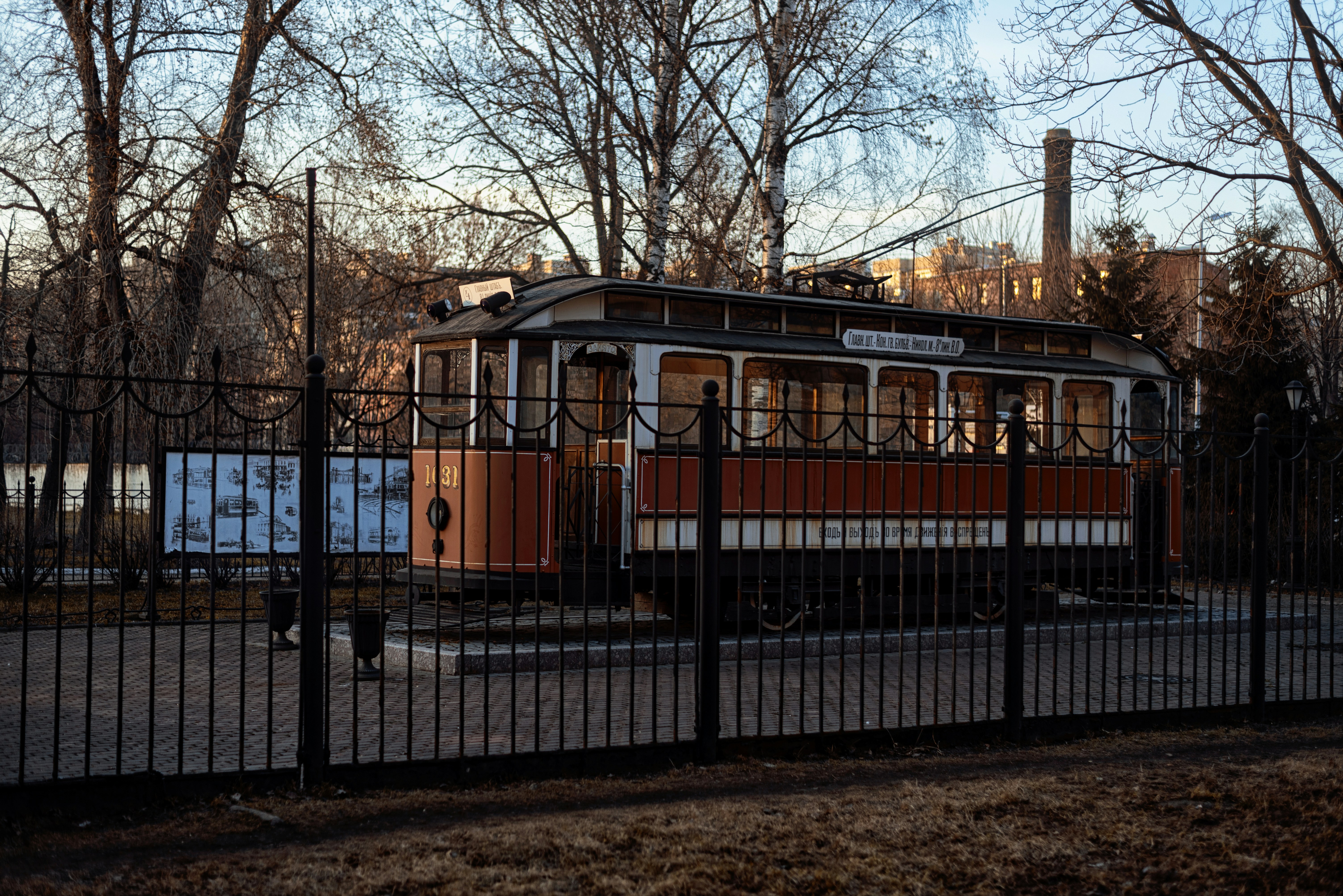 Heritage on Rails: A Sunset Tram Framed by Iron and Trees