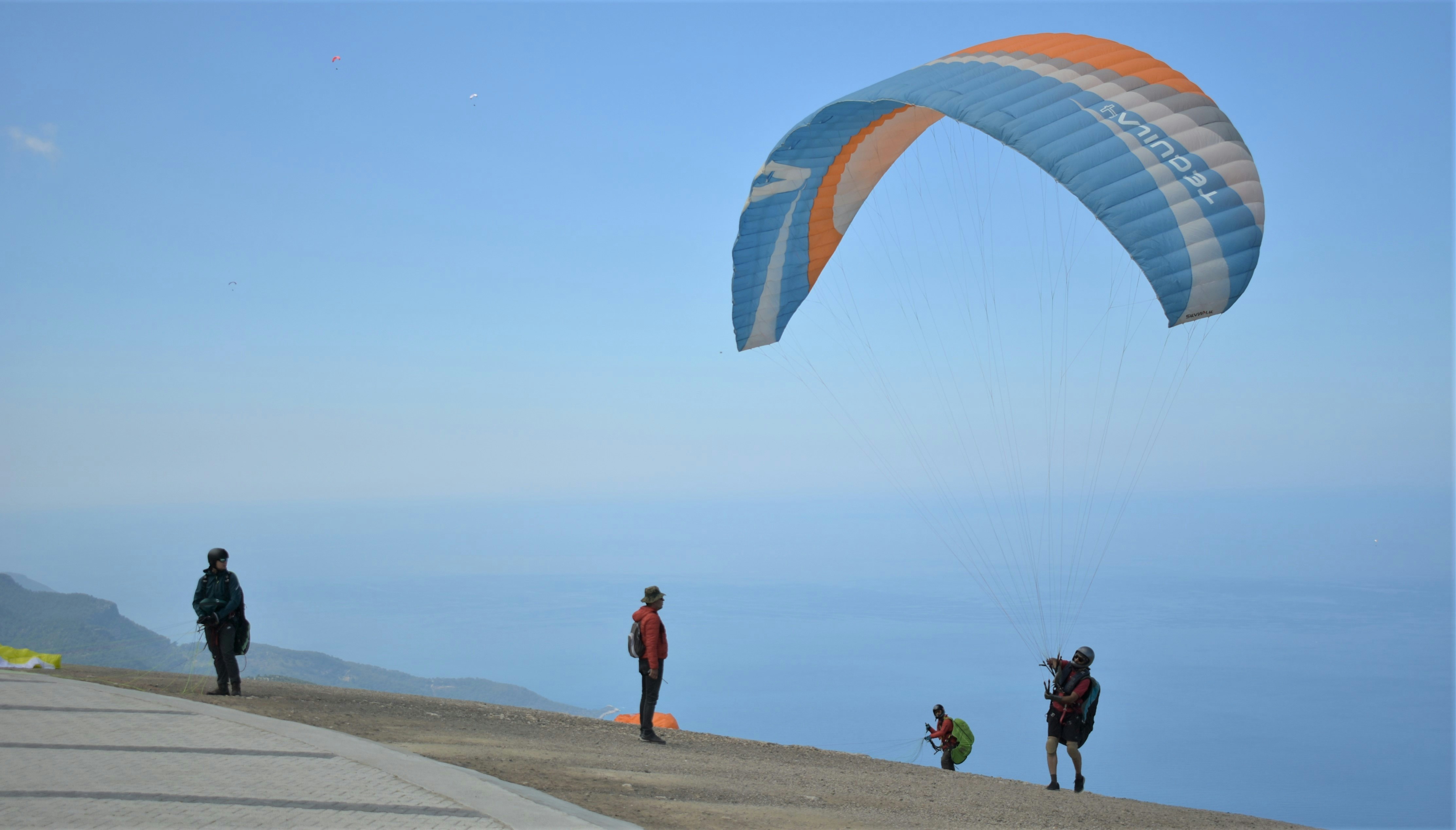 Coastal Lift: Paraglider Rises Above the Cliffside