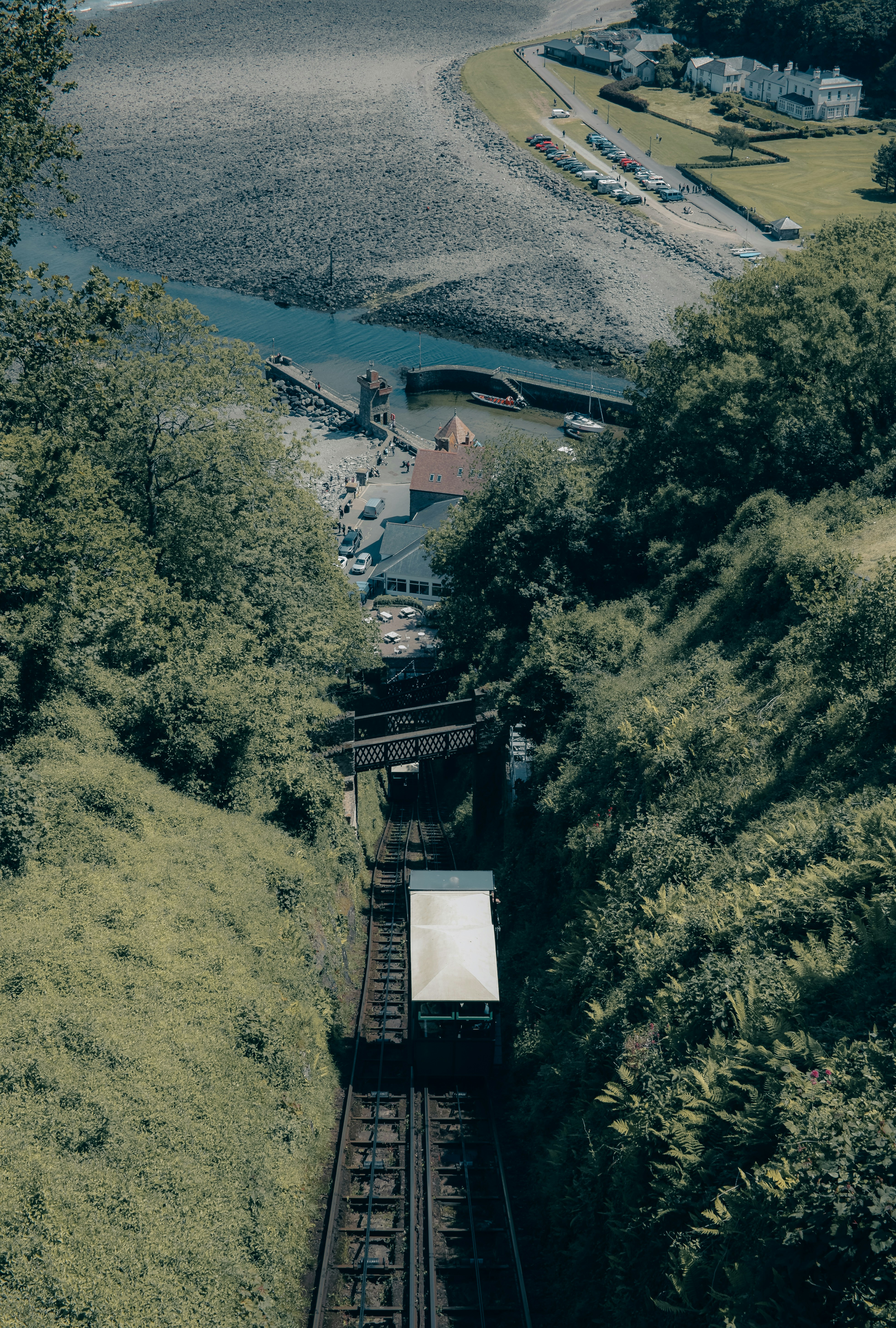 Cabled Descent: Aerial Rail through a Forested Gorge to a Riverside Town