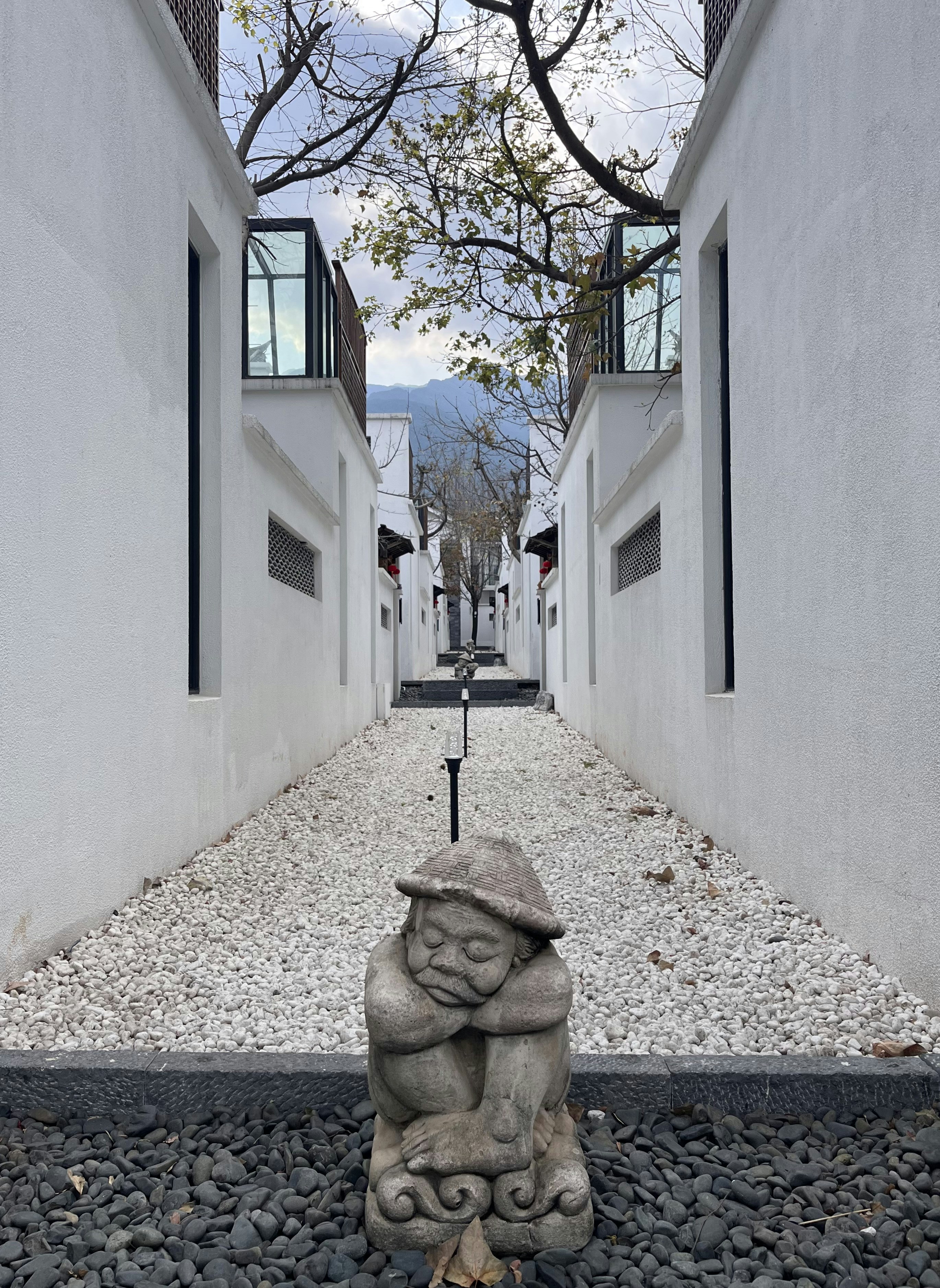 A stone statue of a baby yoshi sitting in the middle of a walkway photo ...