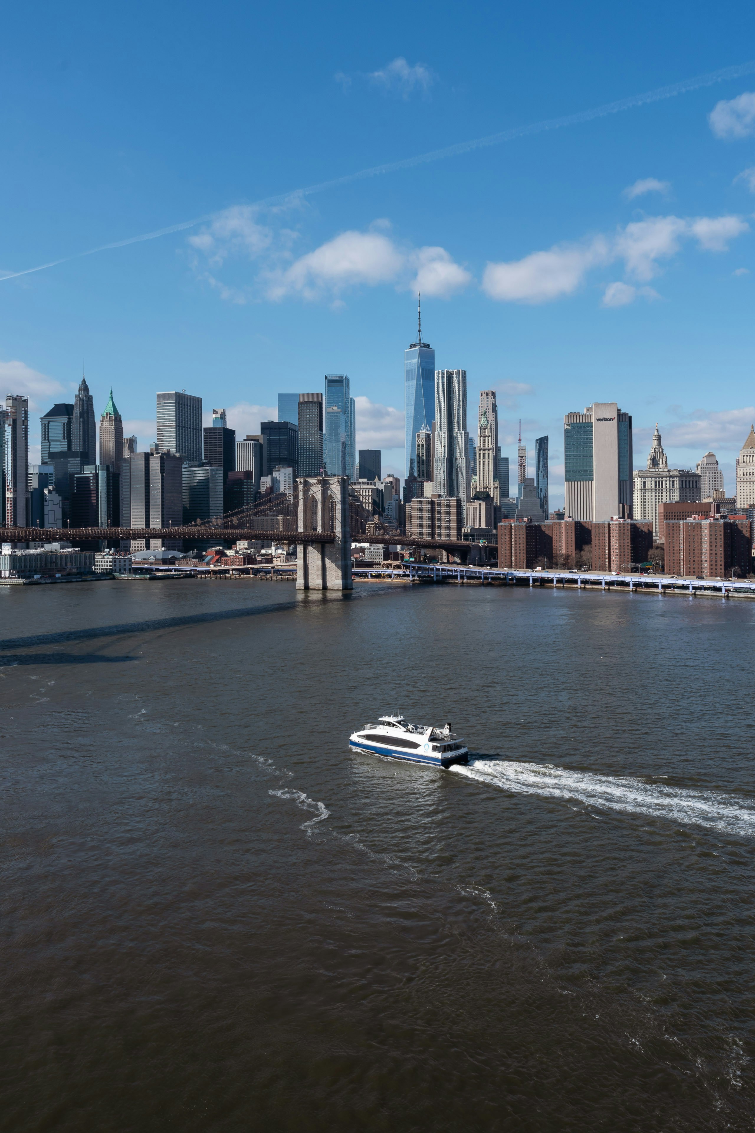 Cityscape ferry through the harbor: Lower Manhattan and Brooklyn Bridge vignette