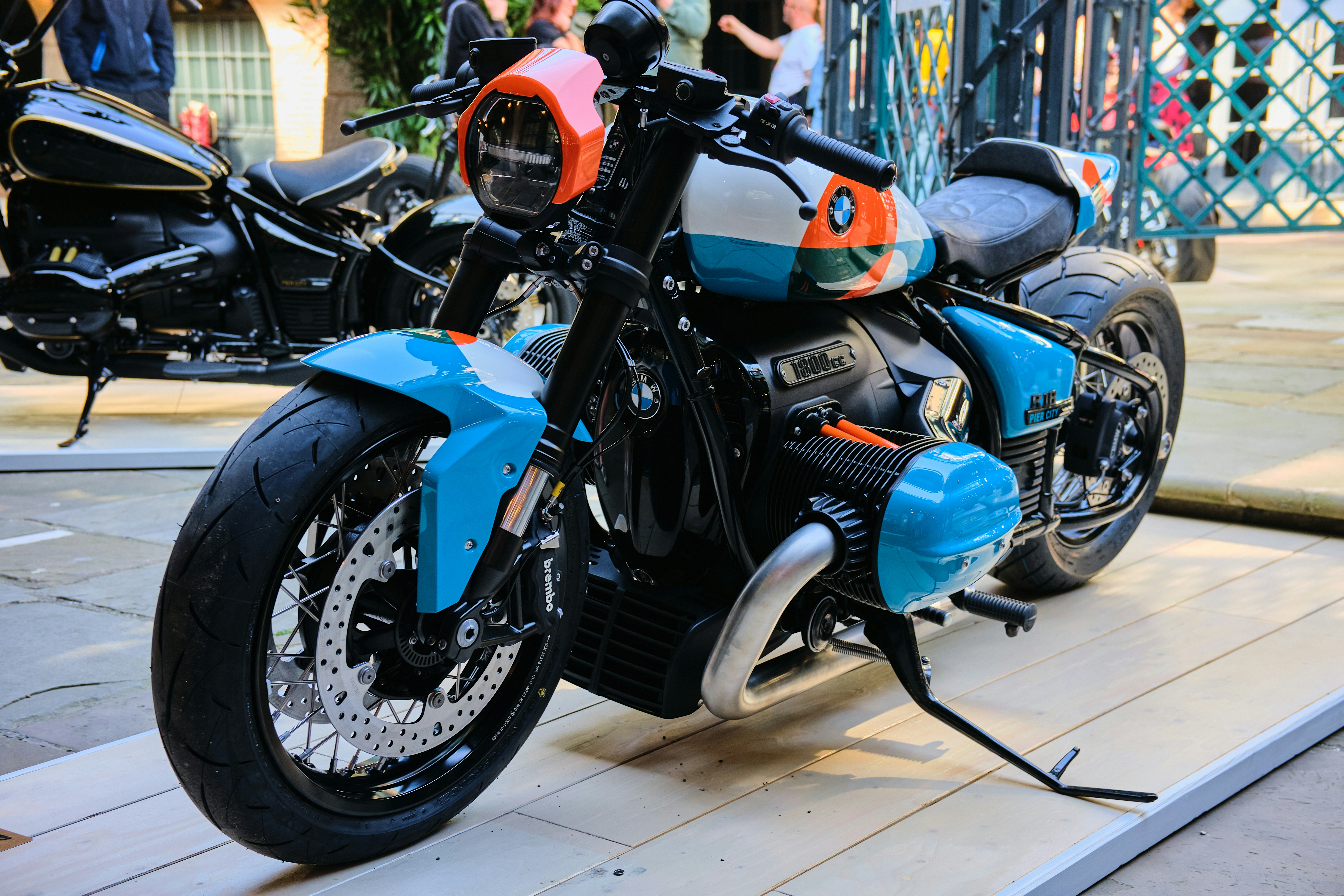 A blue and orange motorcycle parked on a wooden platform photo – Free ...