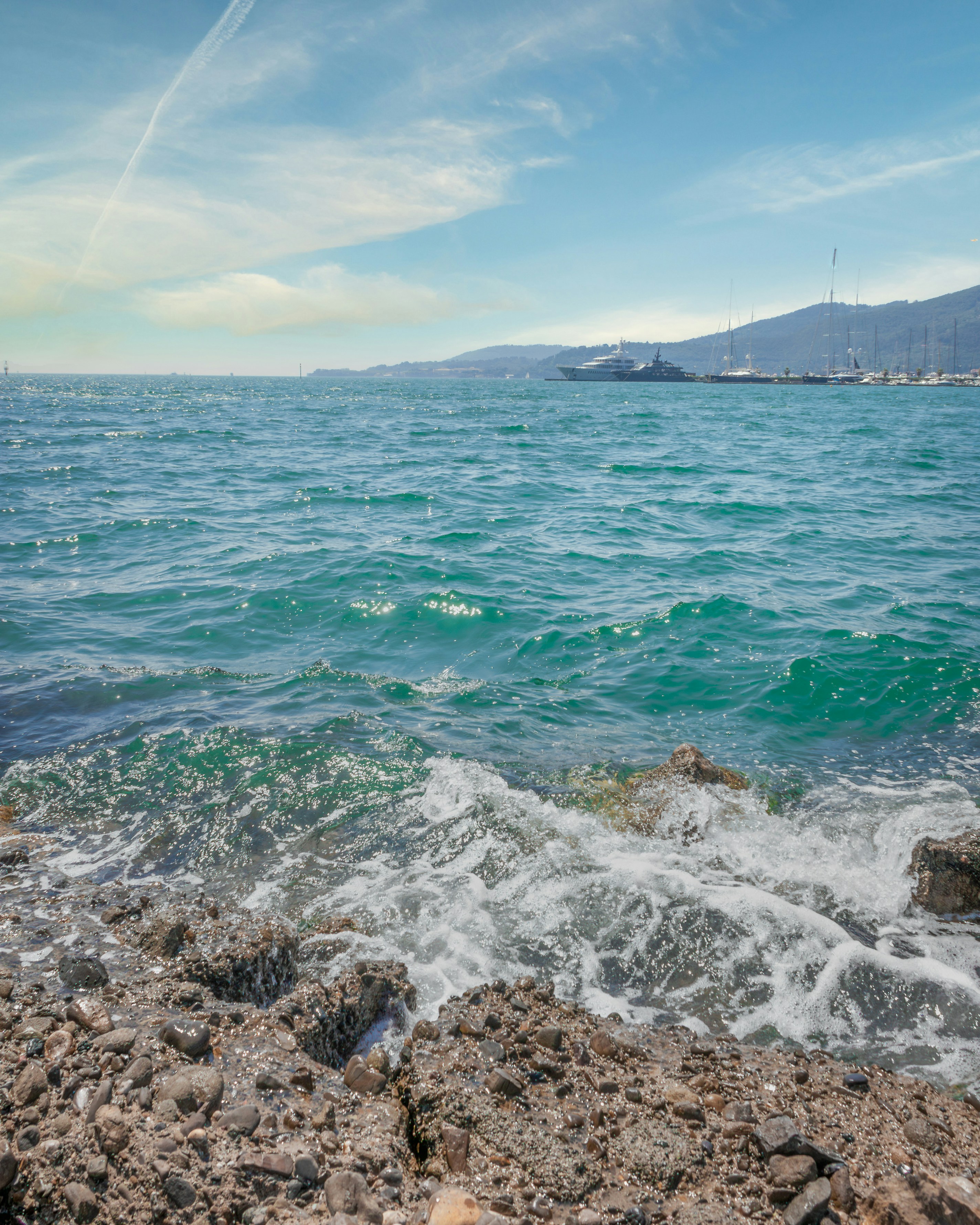 Turquoise Breakers at a Rocky Shoreline Framing a Harbor Horizon