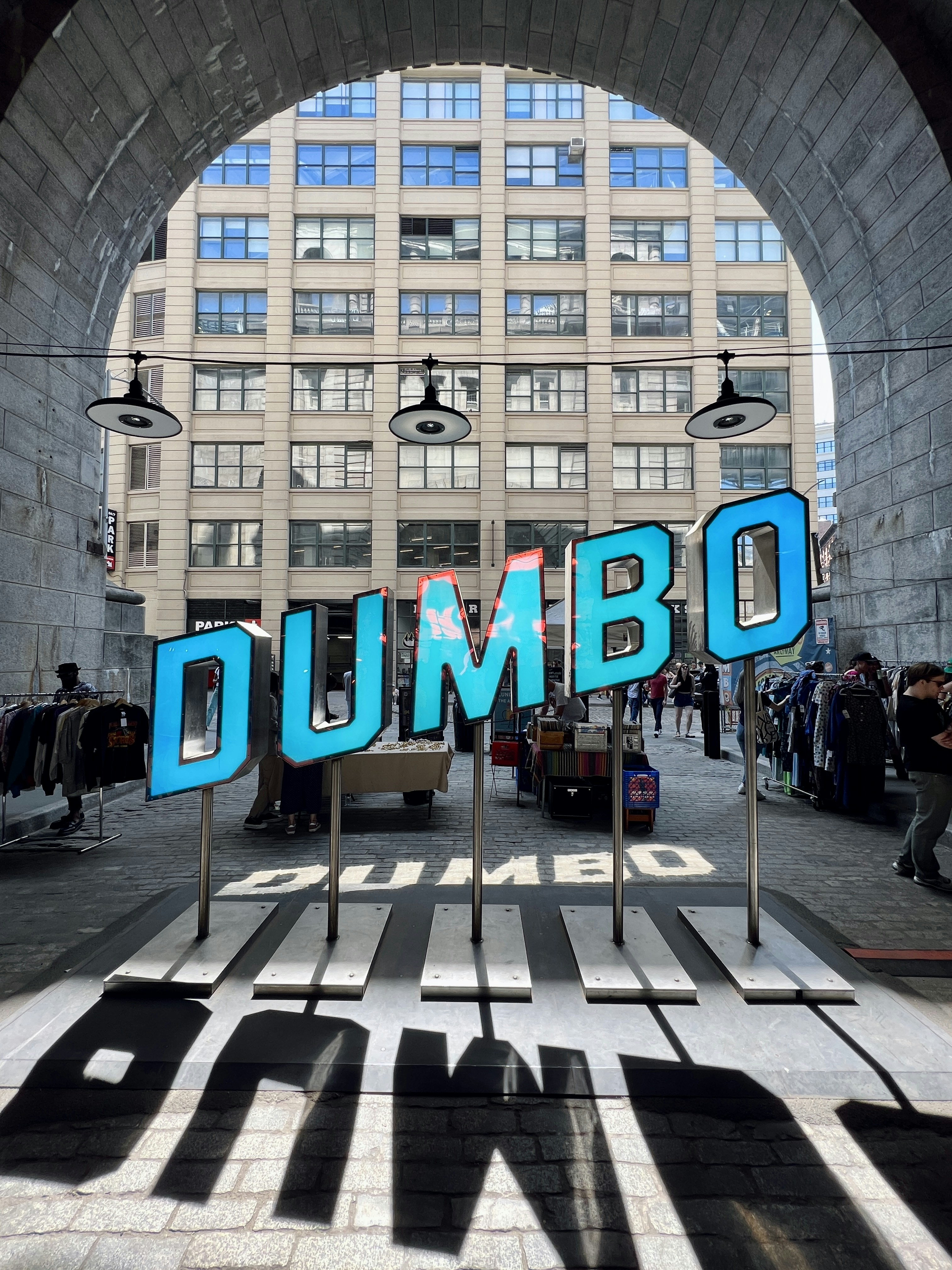DUMBO Under the Arch: Blue Letters Framing a Manhattan Backdrop