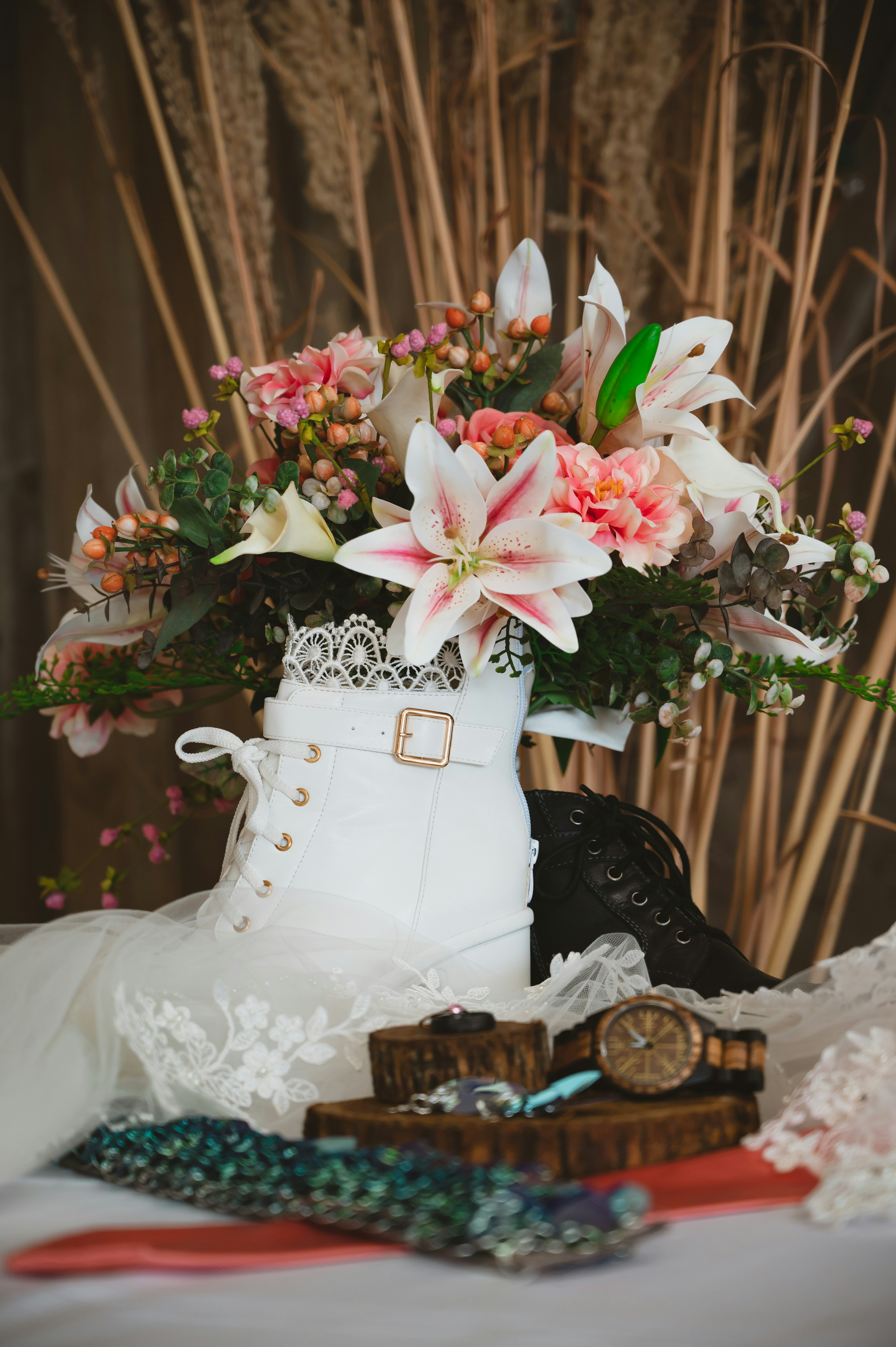 White ankle-boot bouquet: a bridal arrangement resting atop lace and bracelets