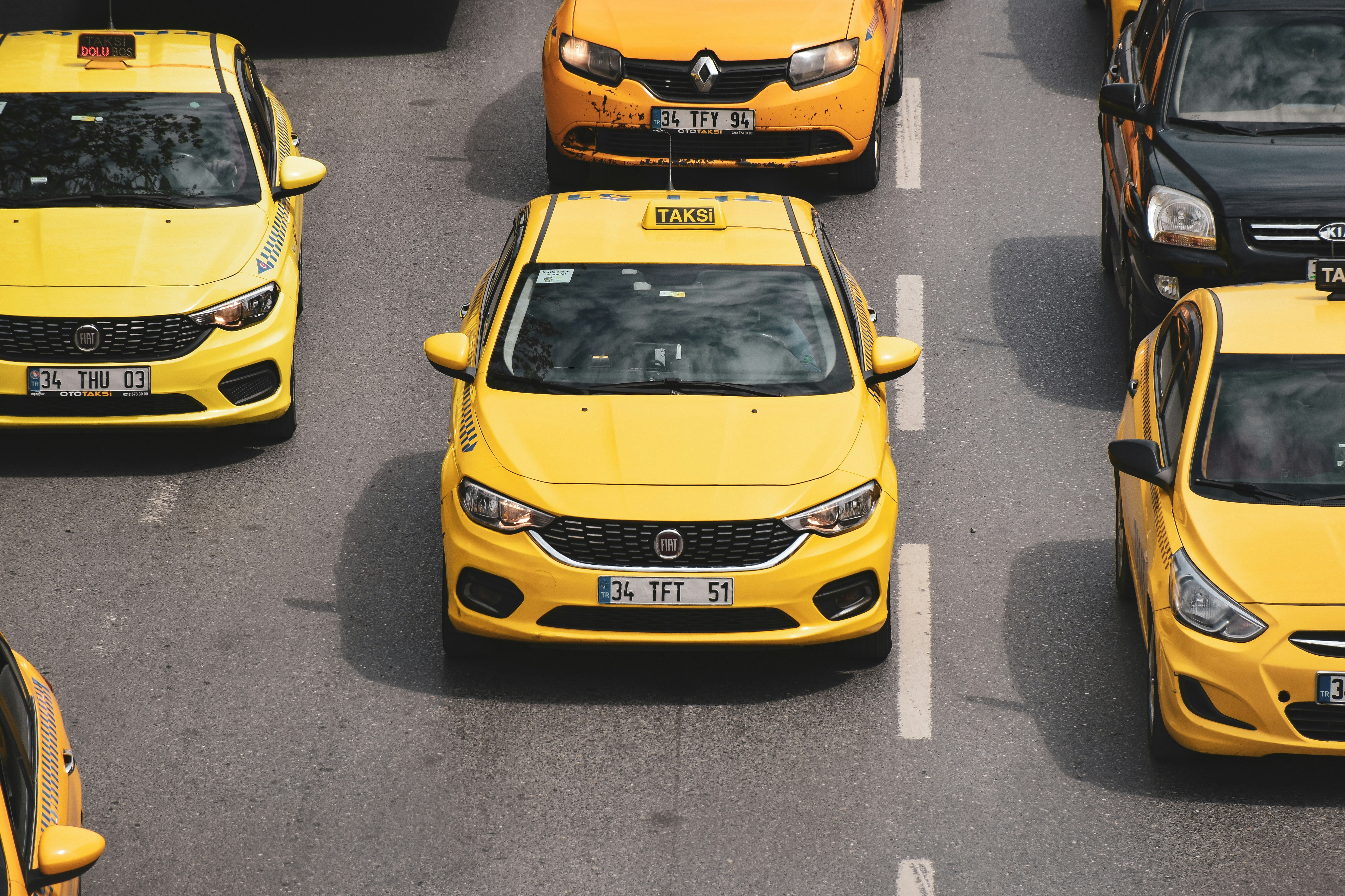 A group of yellow taxis are driving down the street photo – Free Car ...