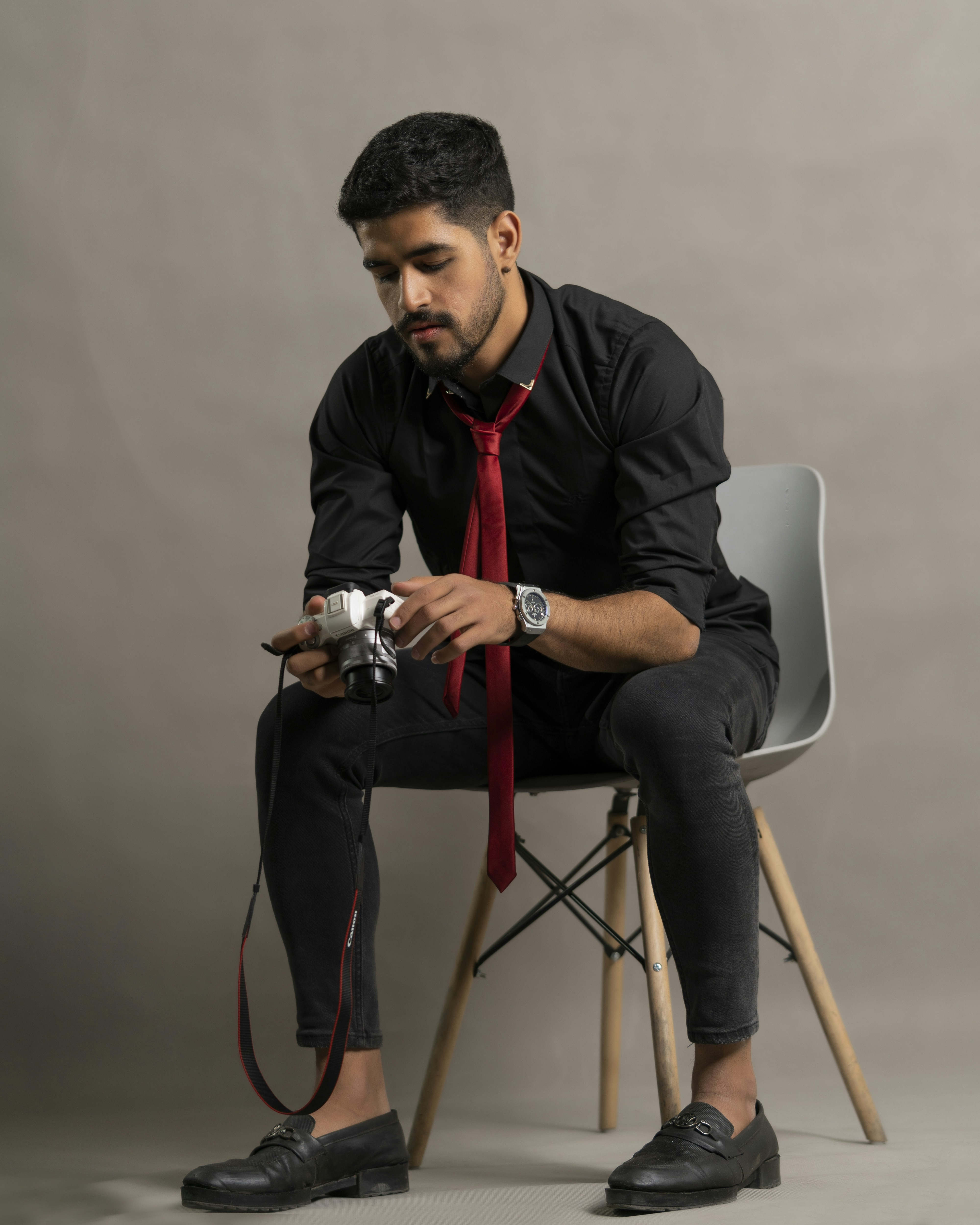 A man sitting on a chair holding a camera photo – Free Man Image on ...
