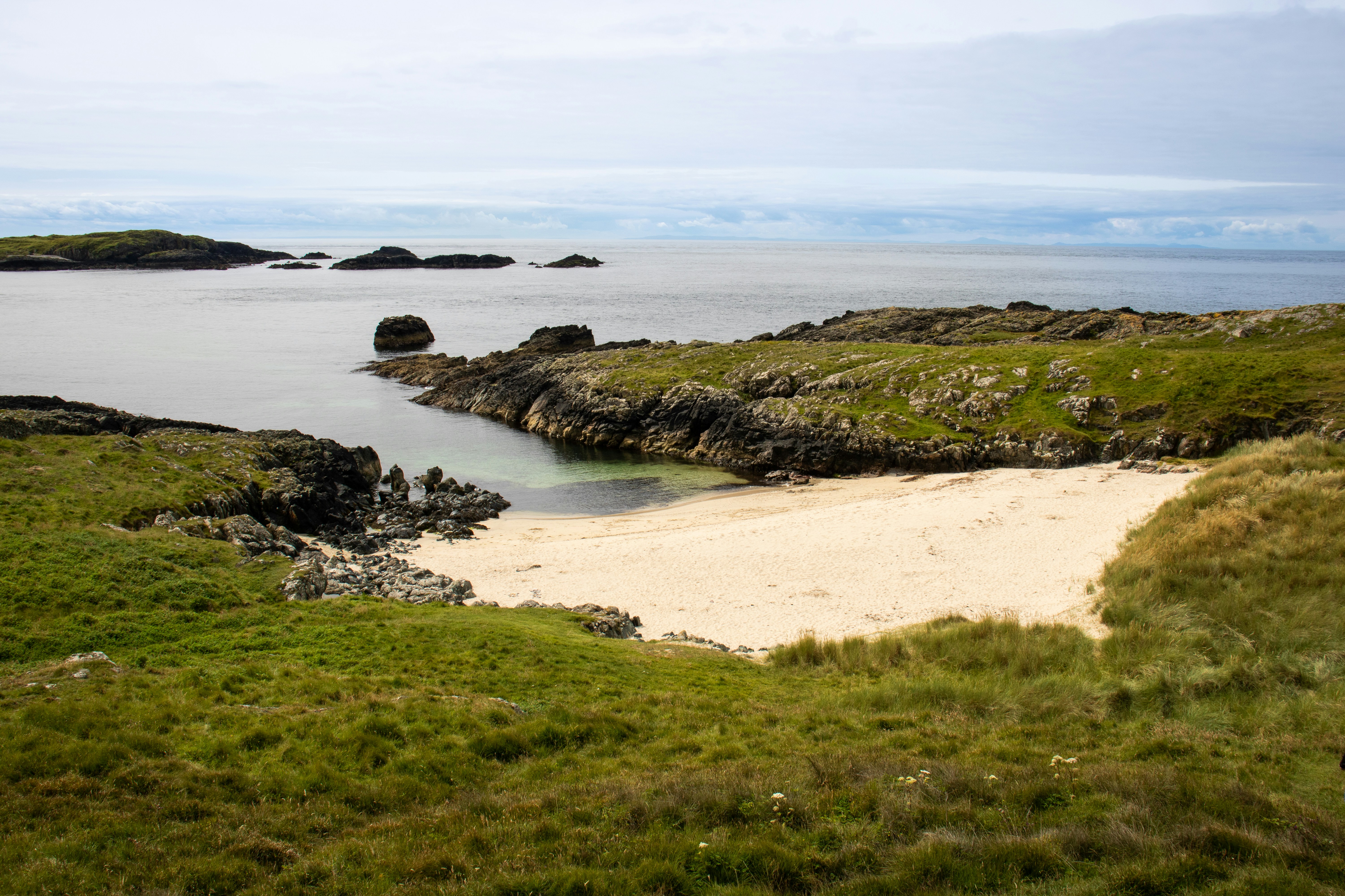 A sandy beach with a body of water in the background photo – Free ...
