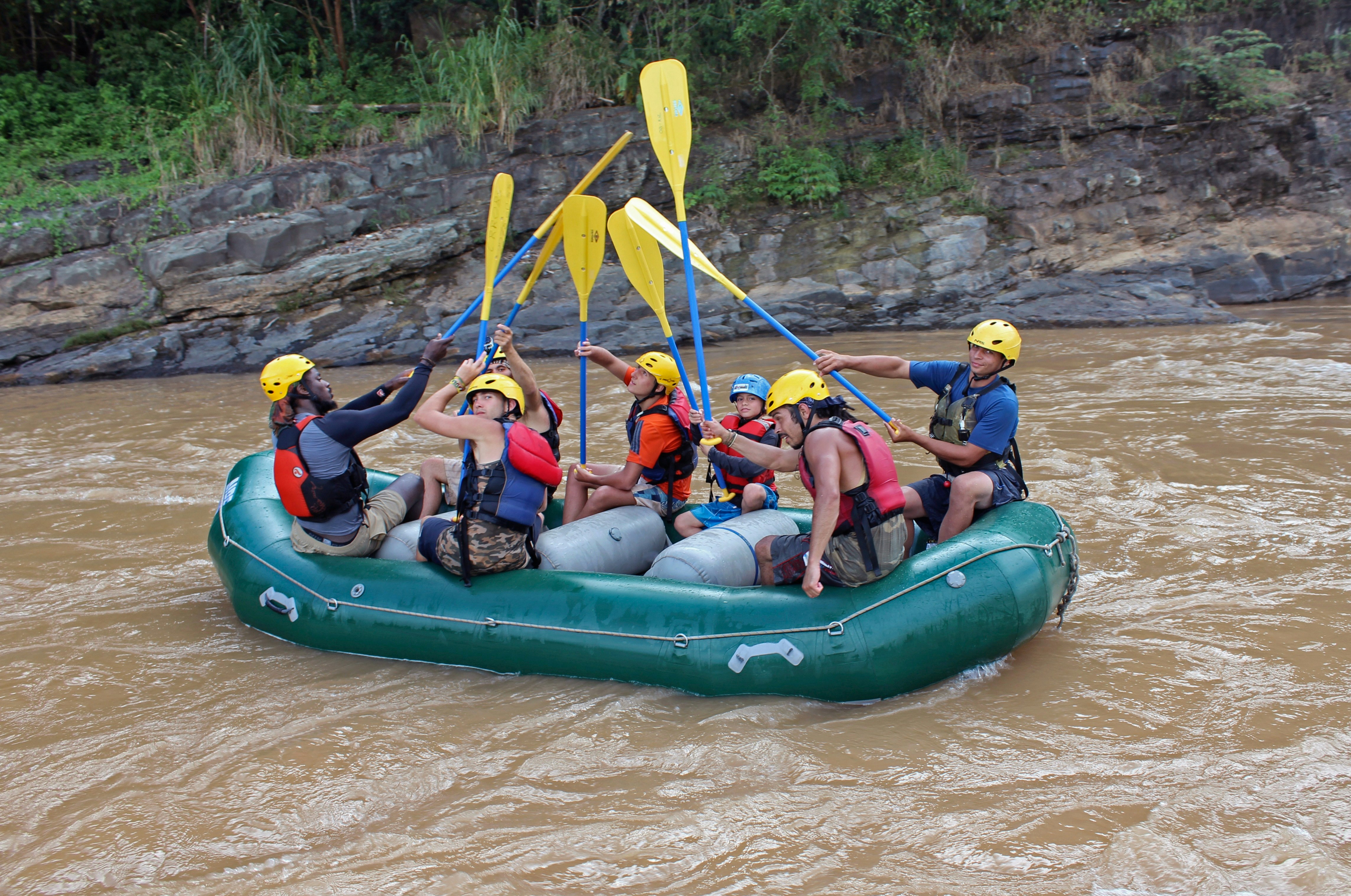 A group of people riding on the back of a raft down a river photo ...
