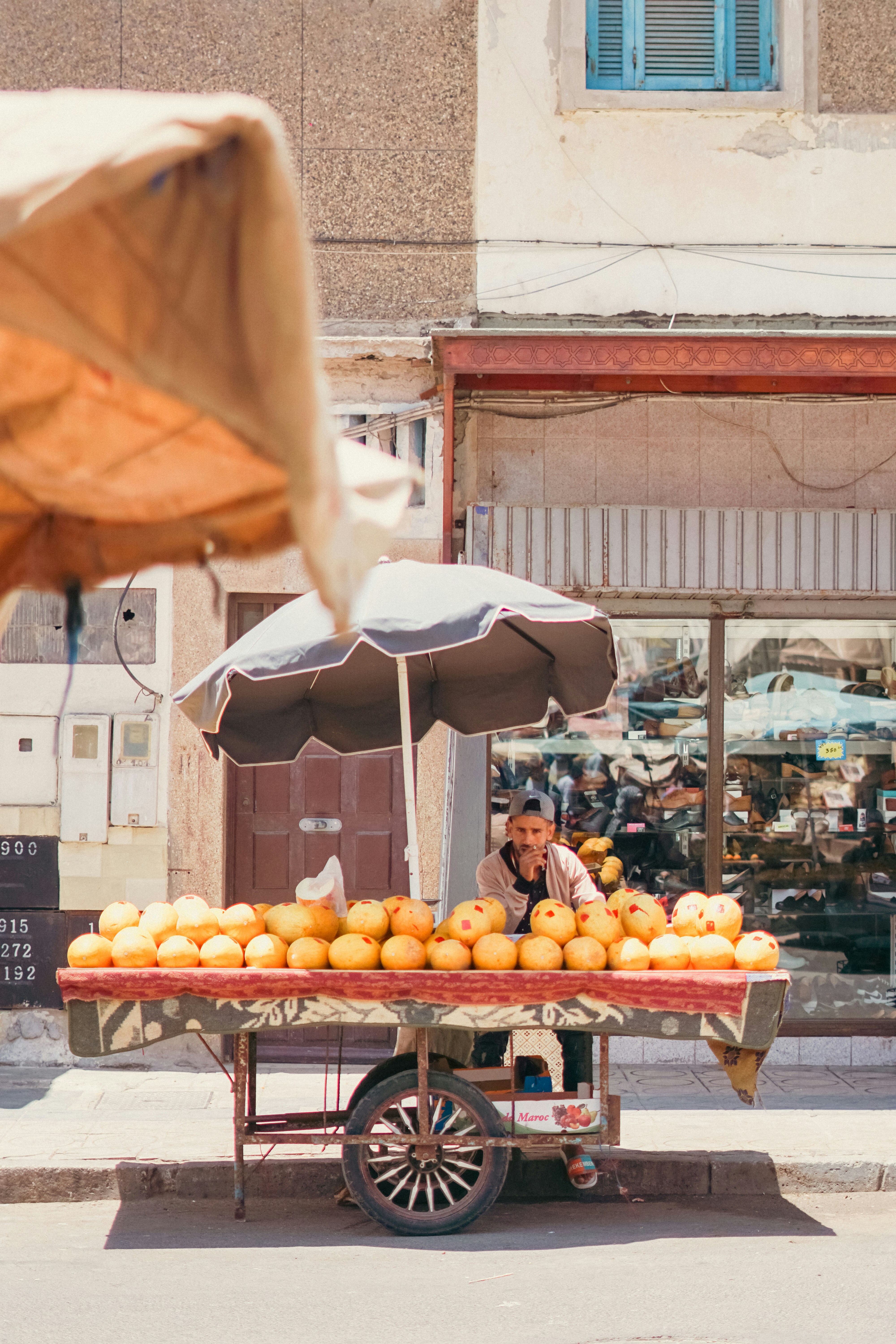 Sunlit Orange Cart at a Quiet City Market