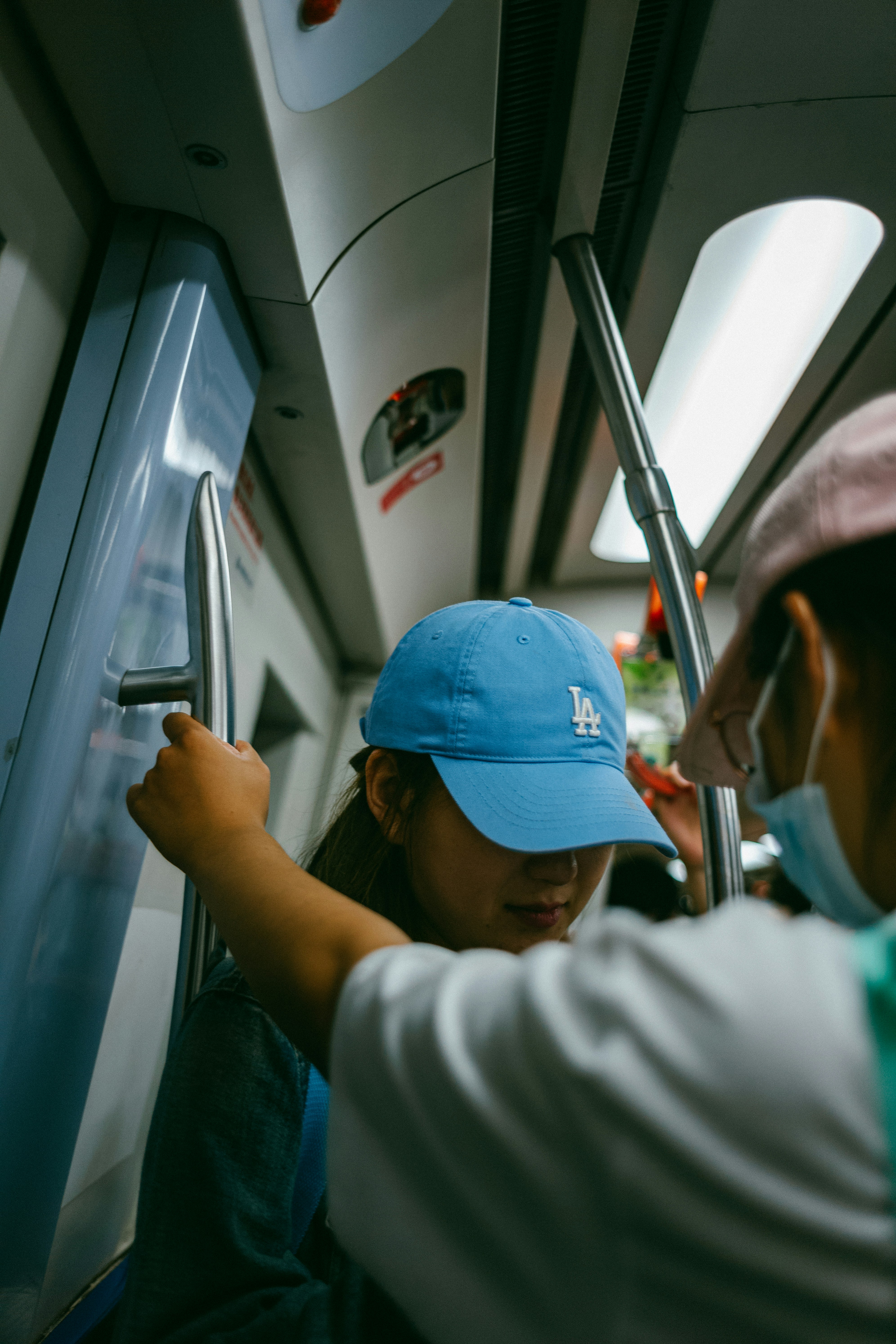 Blue Cap, Quiet Focus: A Moment on the Suburban Subway
