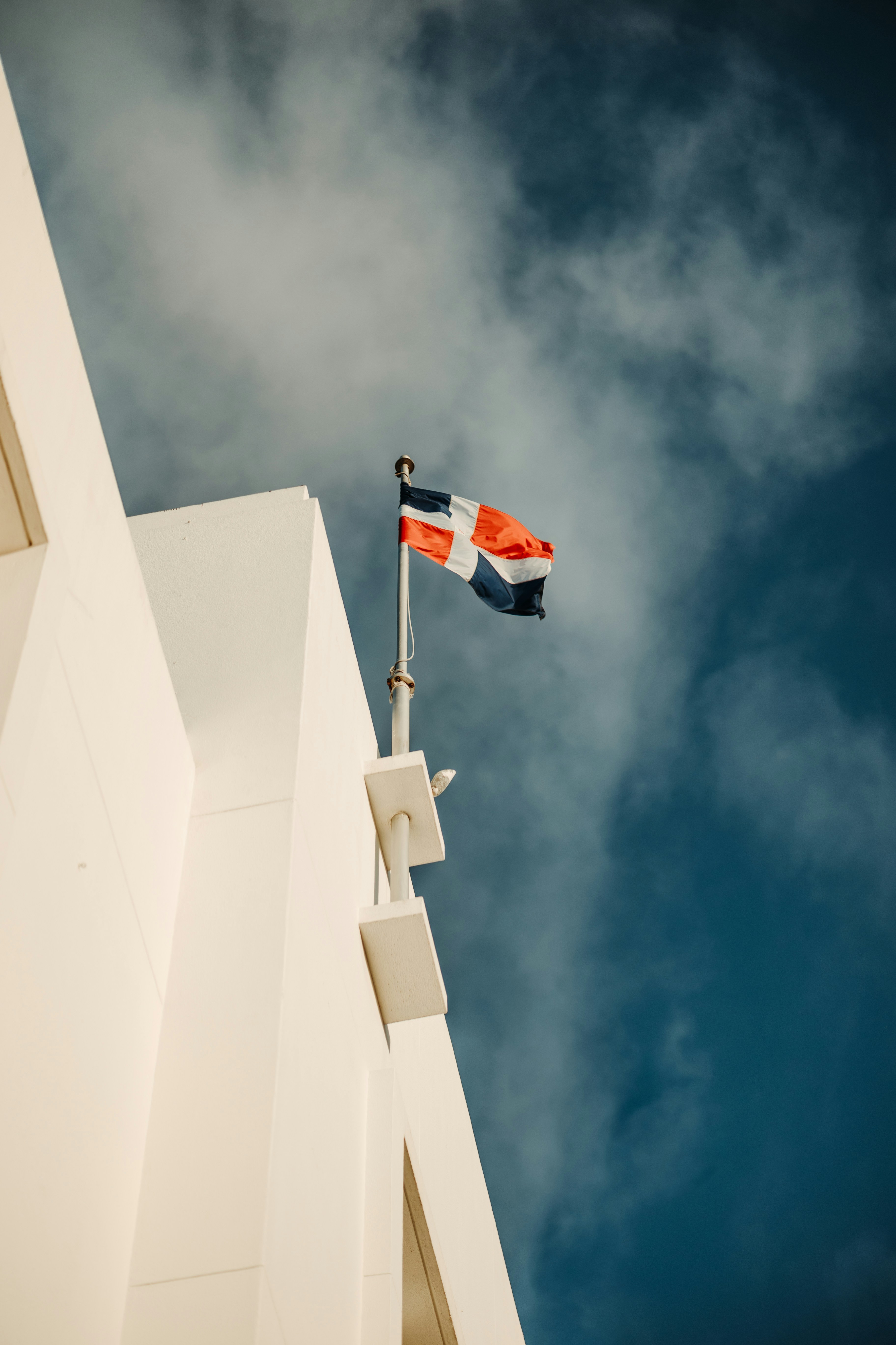French Flag on a Minimal White Facade Under a Bold Sky