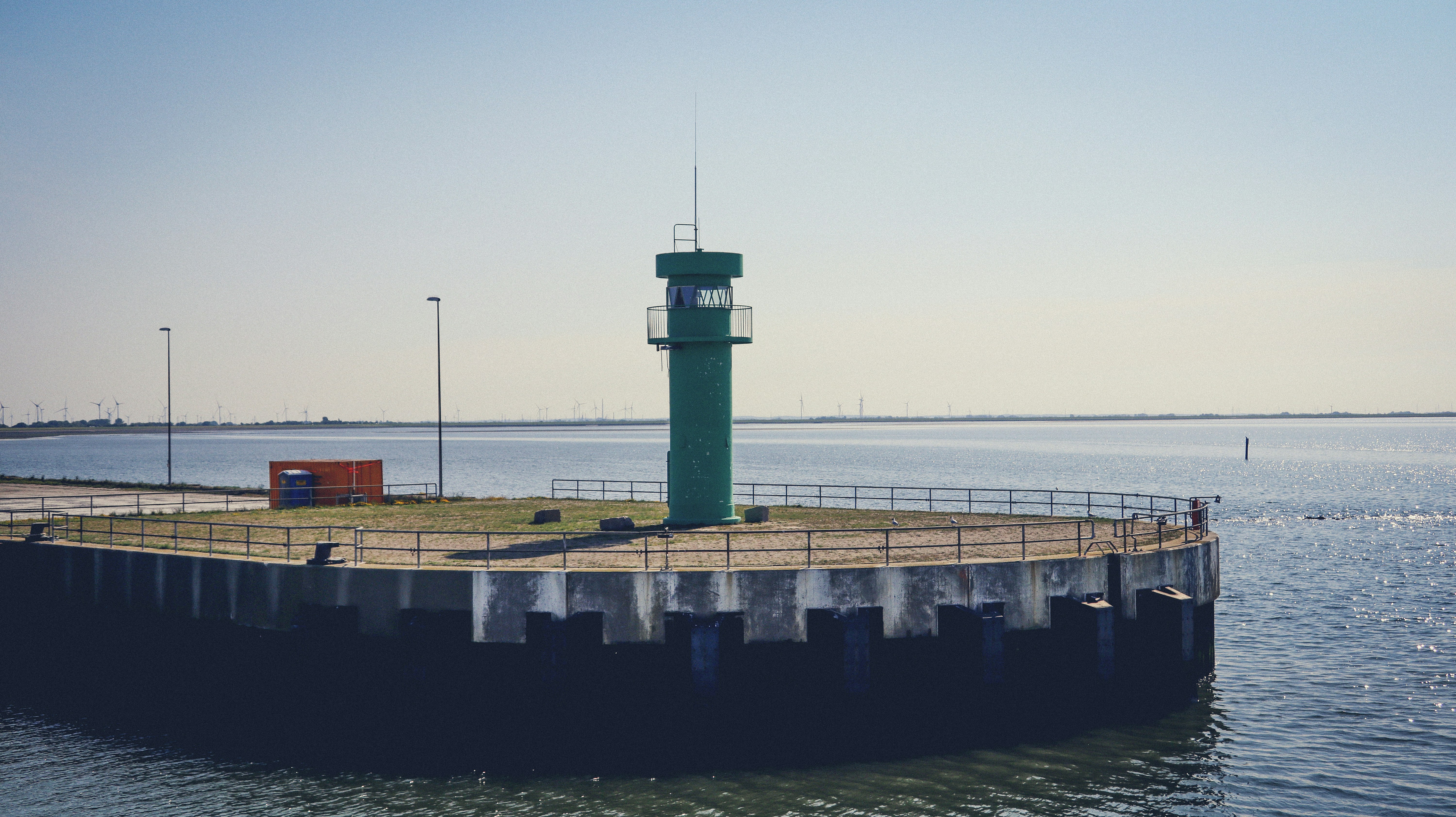 Verdant Lighthouse Guarding a Quiet Harbor Jetty