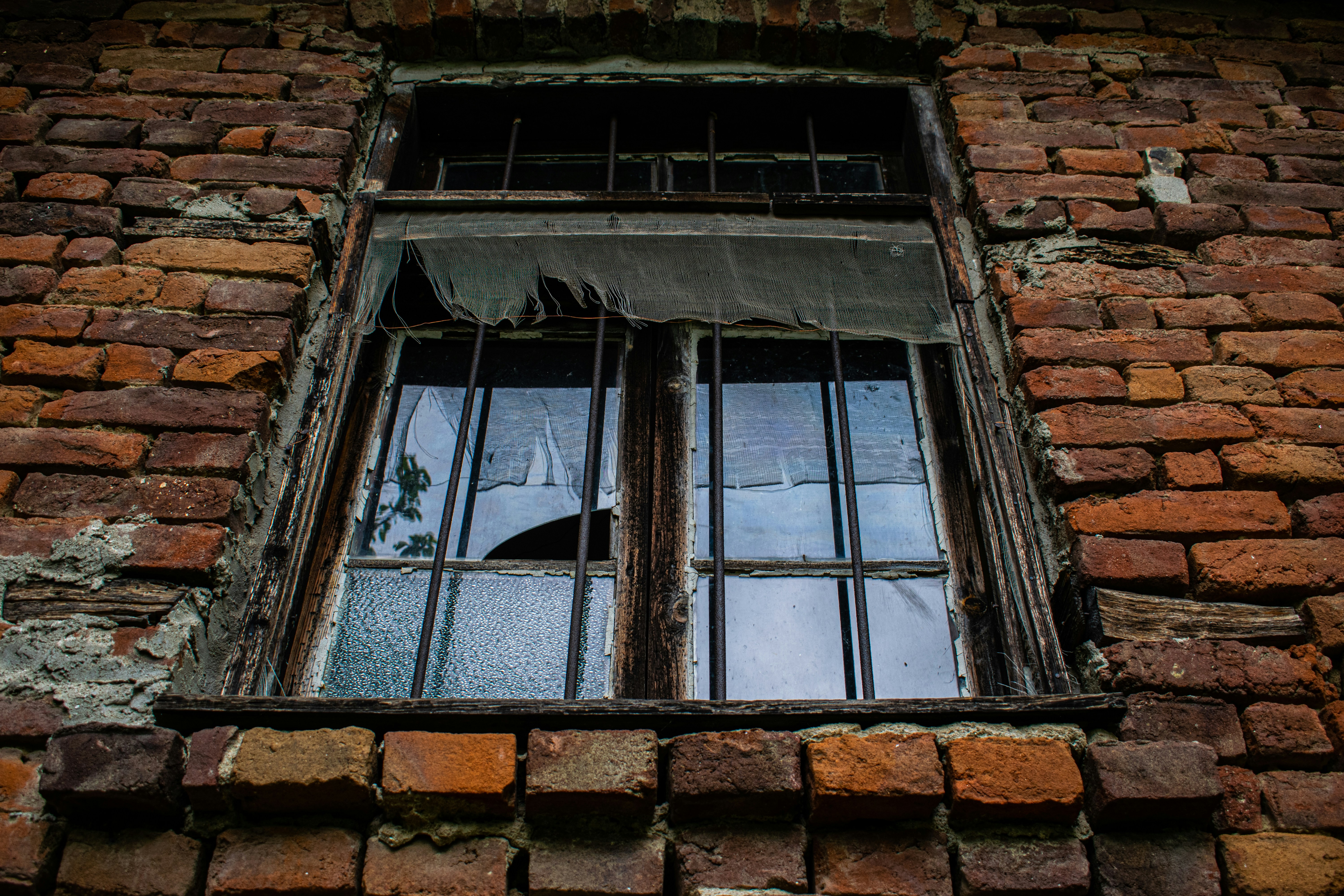 Un viejo edificio de ladrillo con una ventana rota foto – Imagen de ...