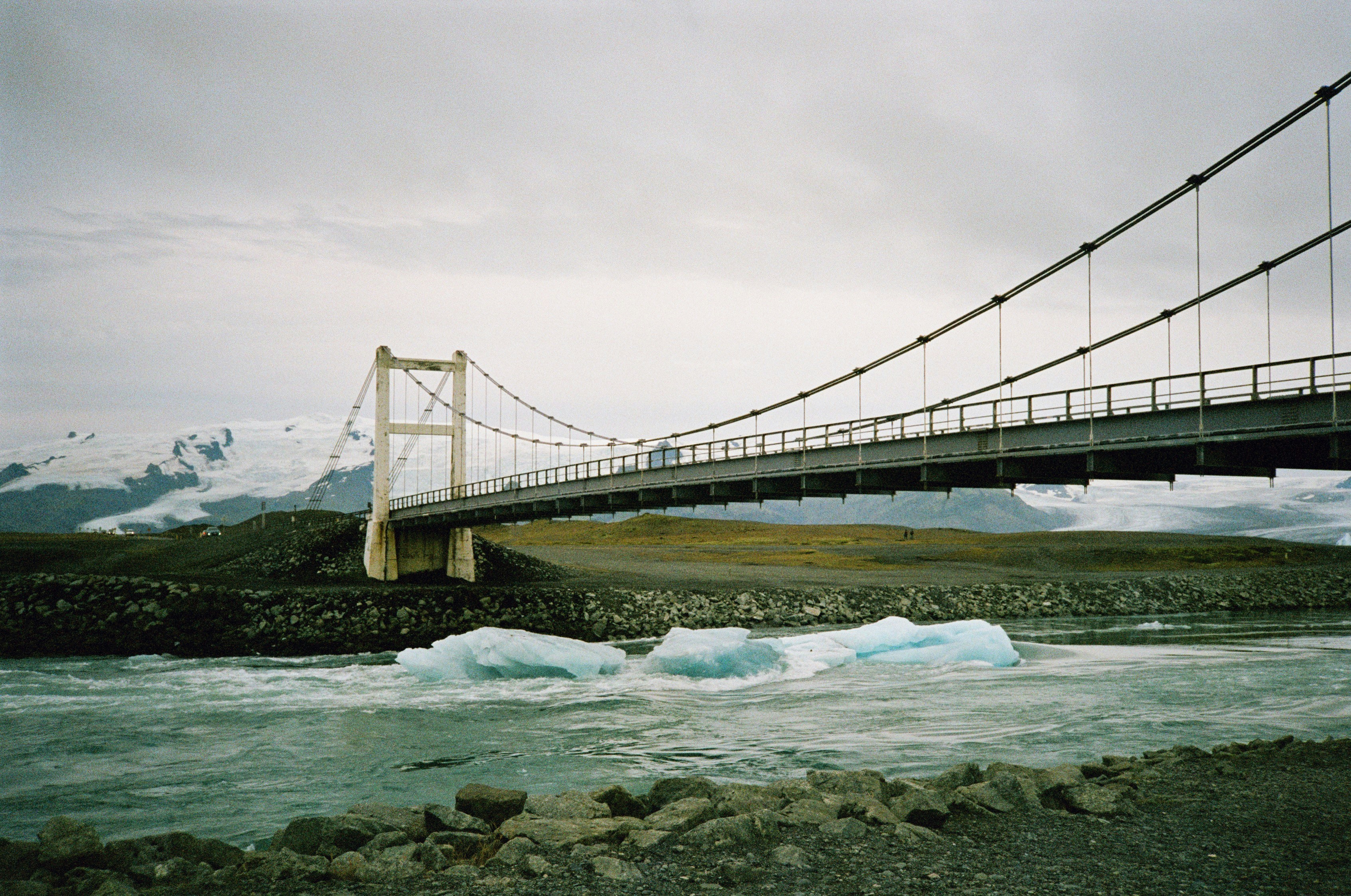 Icebound Span: A Suspension Bridge Crossing a Turquoise Arctic Inlet