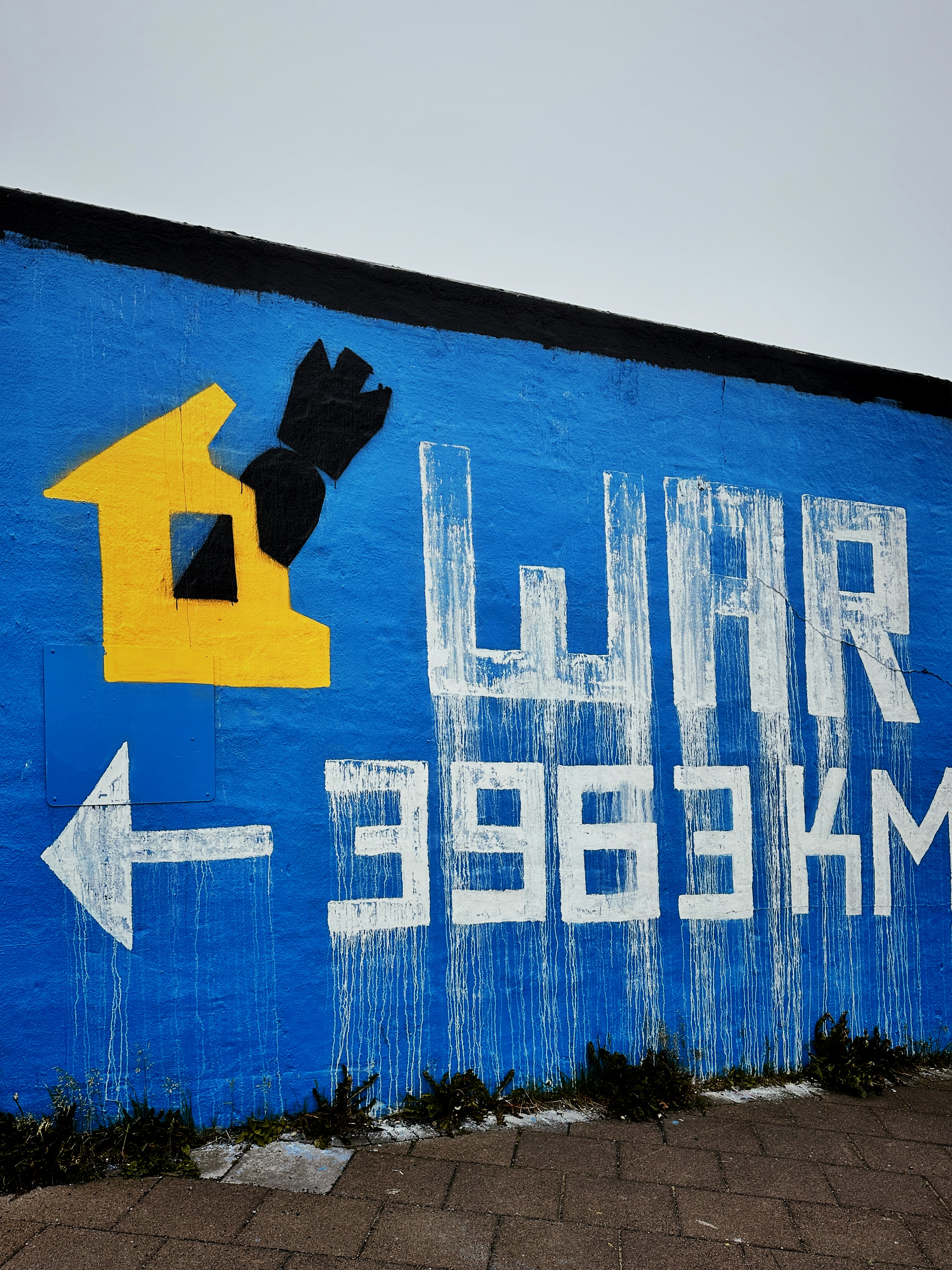 Blue Wall, Bright Arrow: A Street Art Signpost Captured