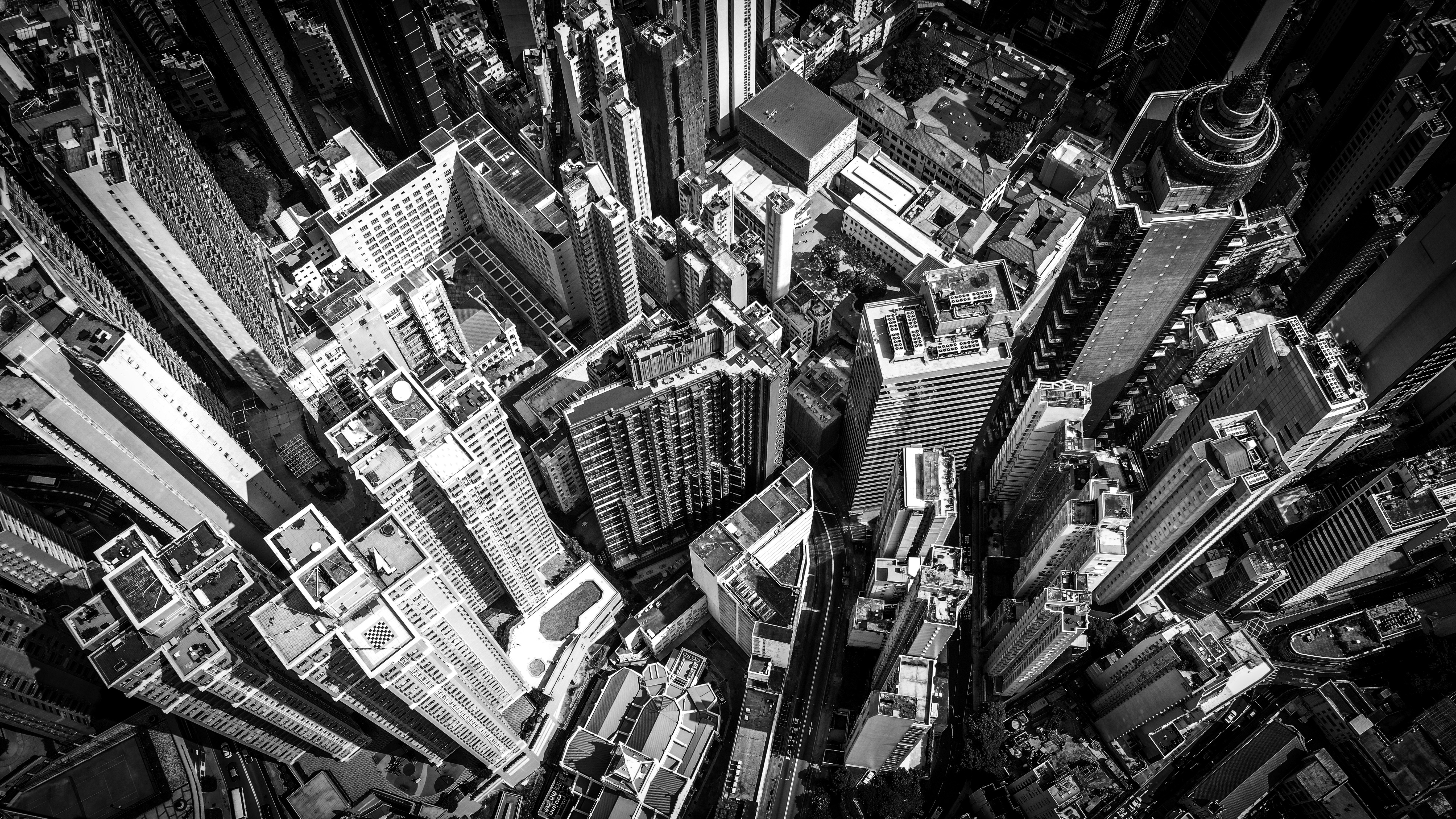 Aerial view of a dense urban landscape showcasing the intricate patterns of skyscrapers in black and white. The geometric shapes create a striking visual contrast.