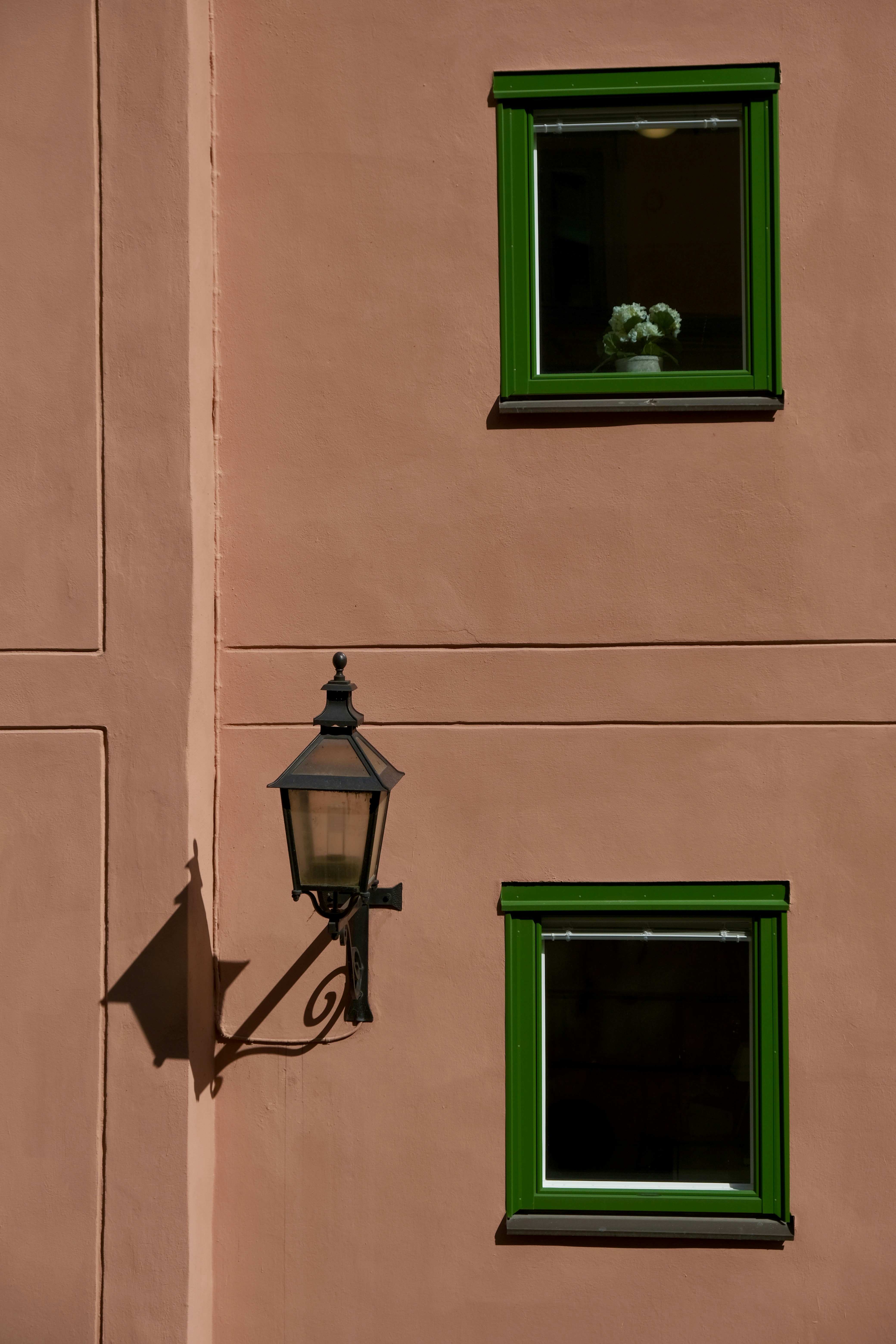 Emerald Frames and a Quiet Lantern on a Peach Facade