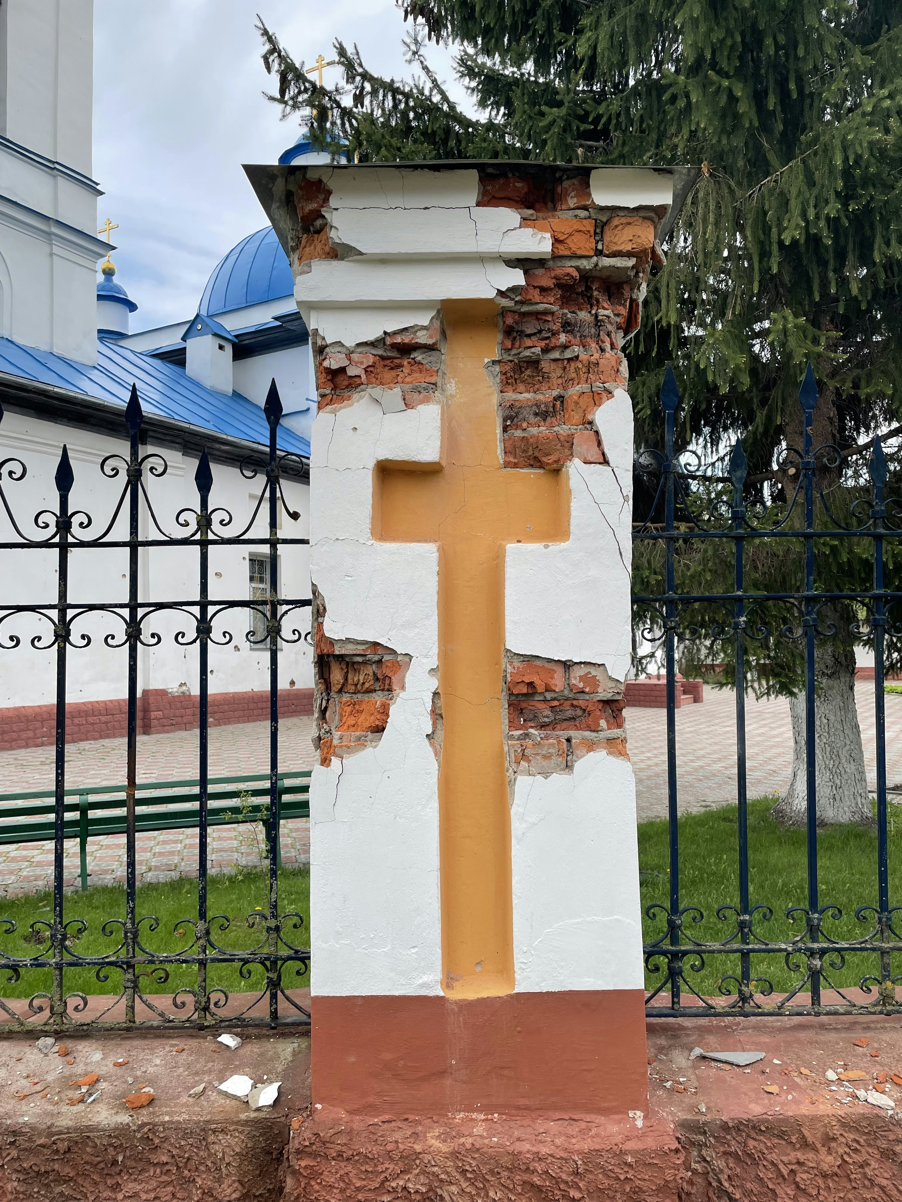 Cracked Pillar with Golden Cross: A Quiet Boundary Between Brick and Bloom