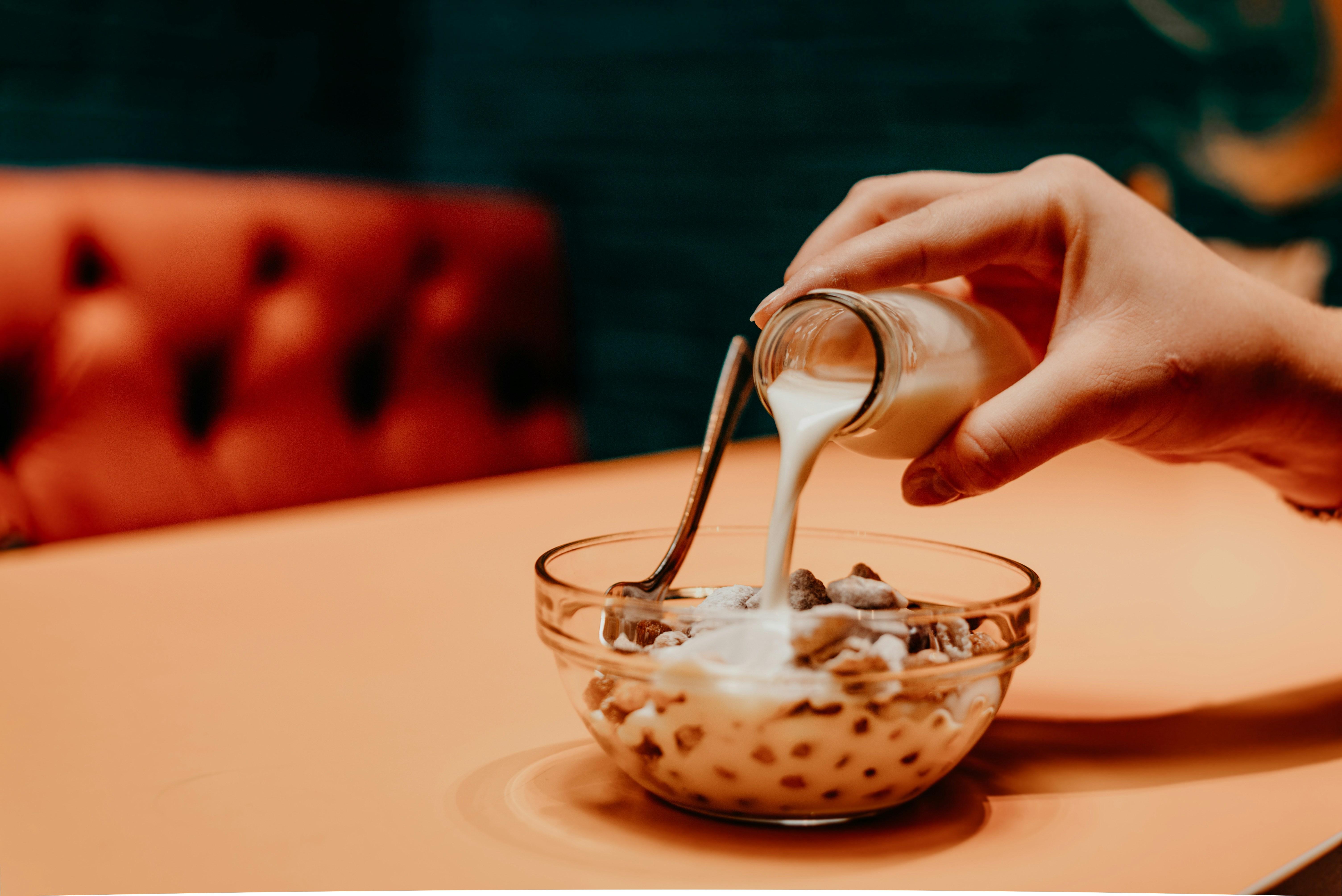 A person pouring milk into a bowl of food photo – Free Pour Image on ...