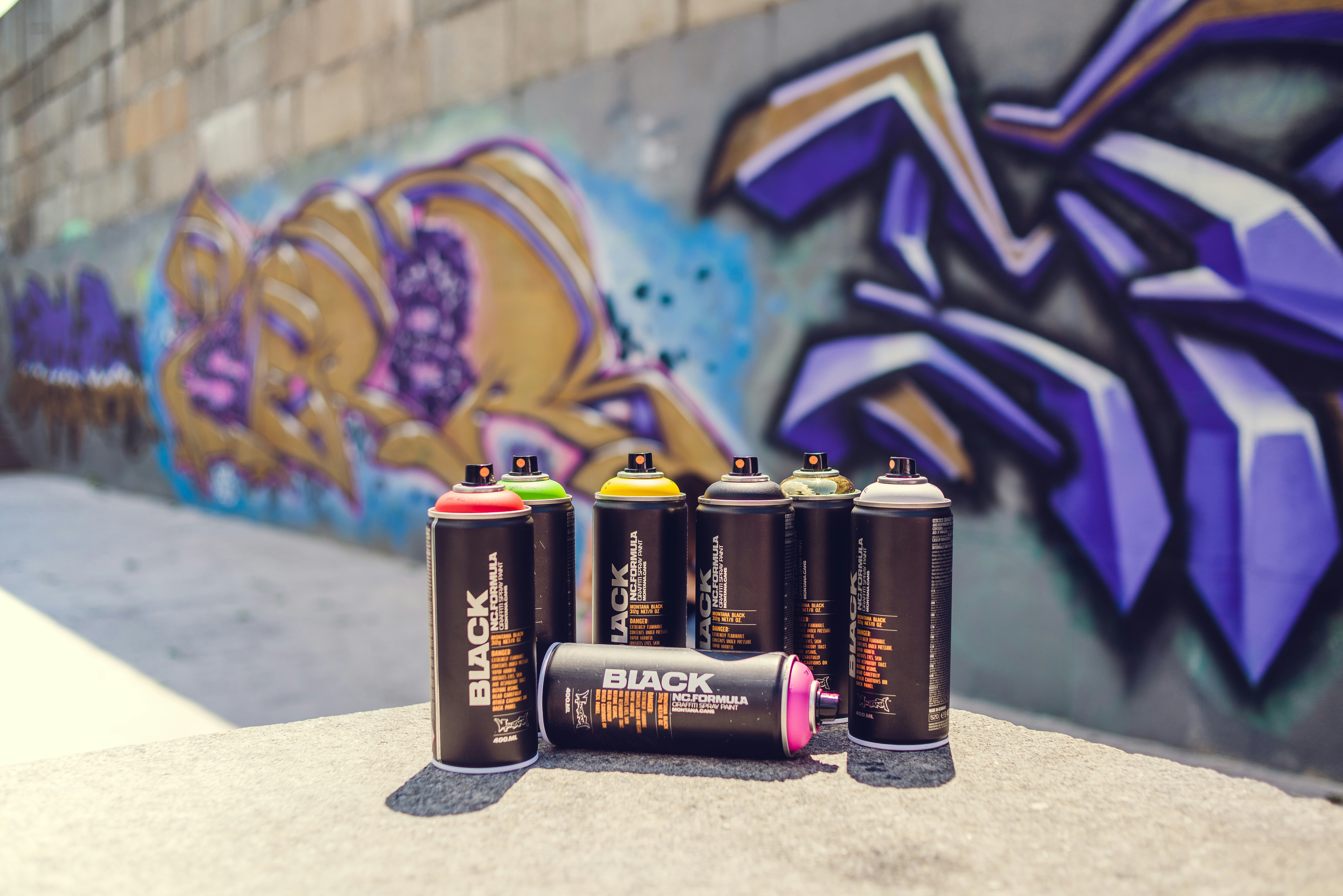 Sparkcan Still Life: A Row of Blackout Spray Cans Against a Vivid Concrete Backdrop