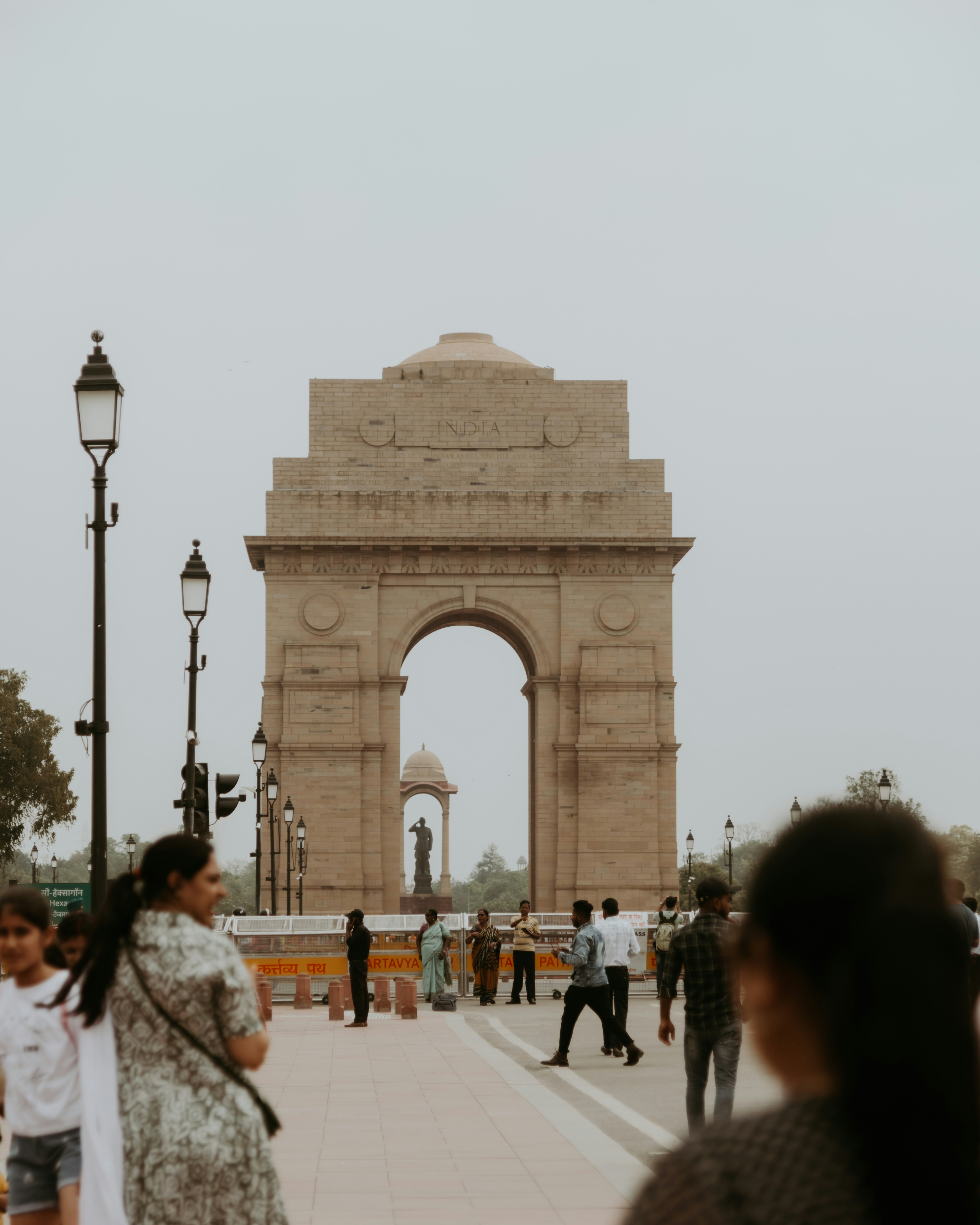 India gate, New Delhi, India | a group of people standing around a stone arch