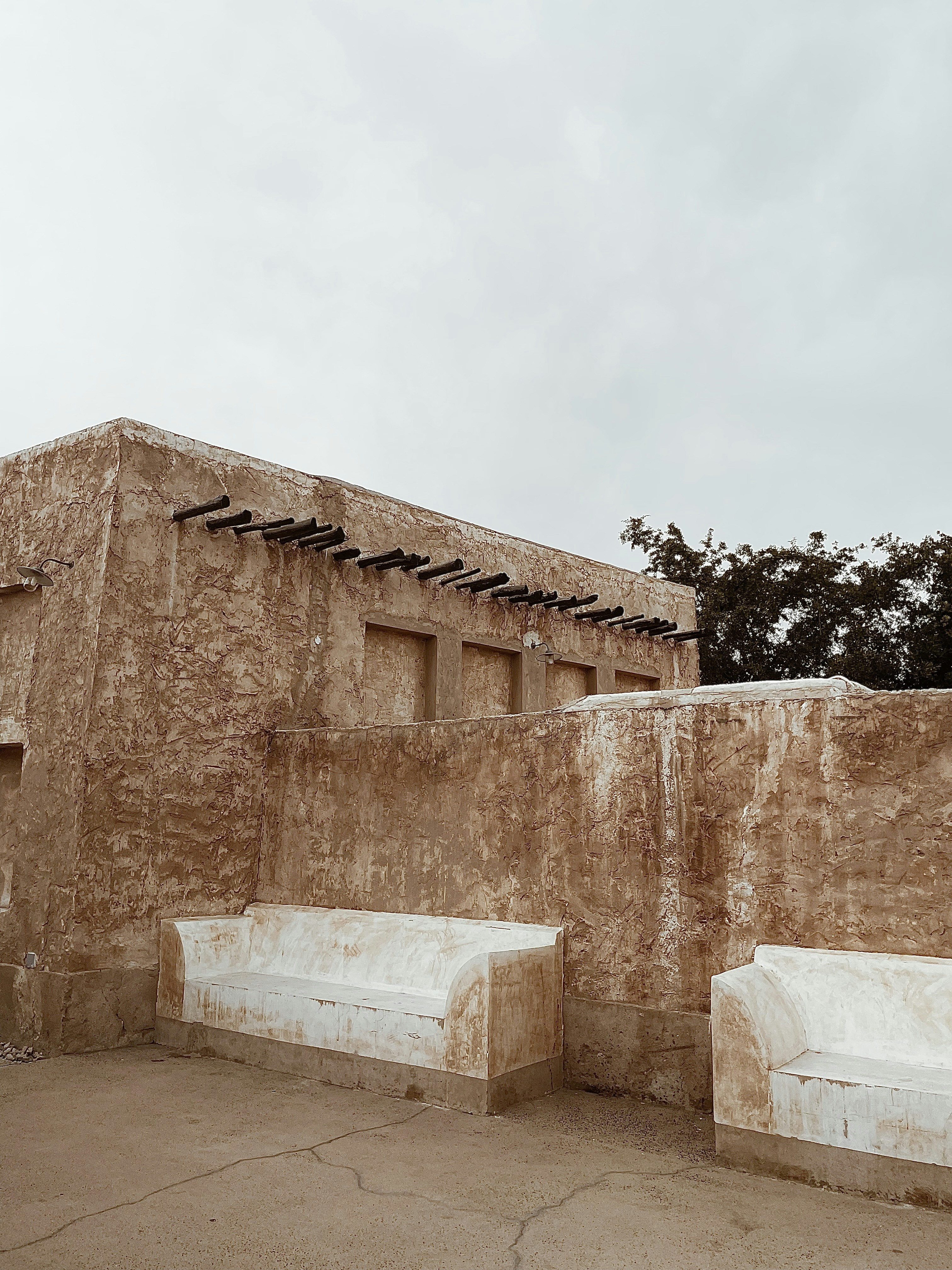 A couple of benches sitting in front of a building photo – Free Qatar ...