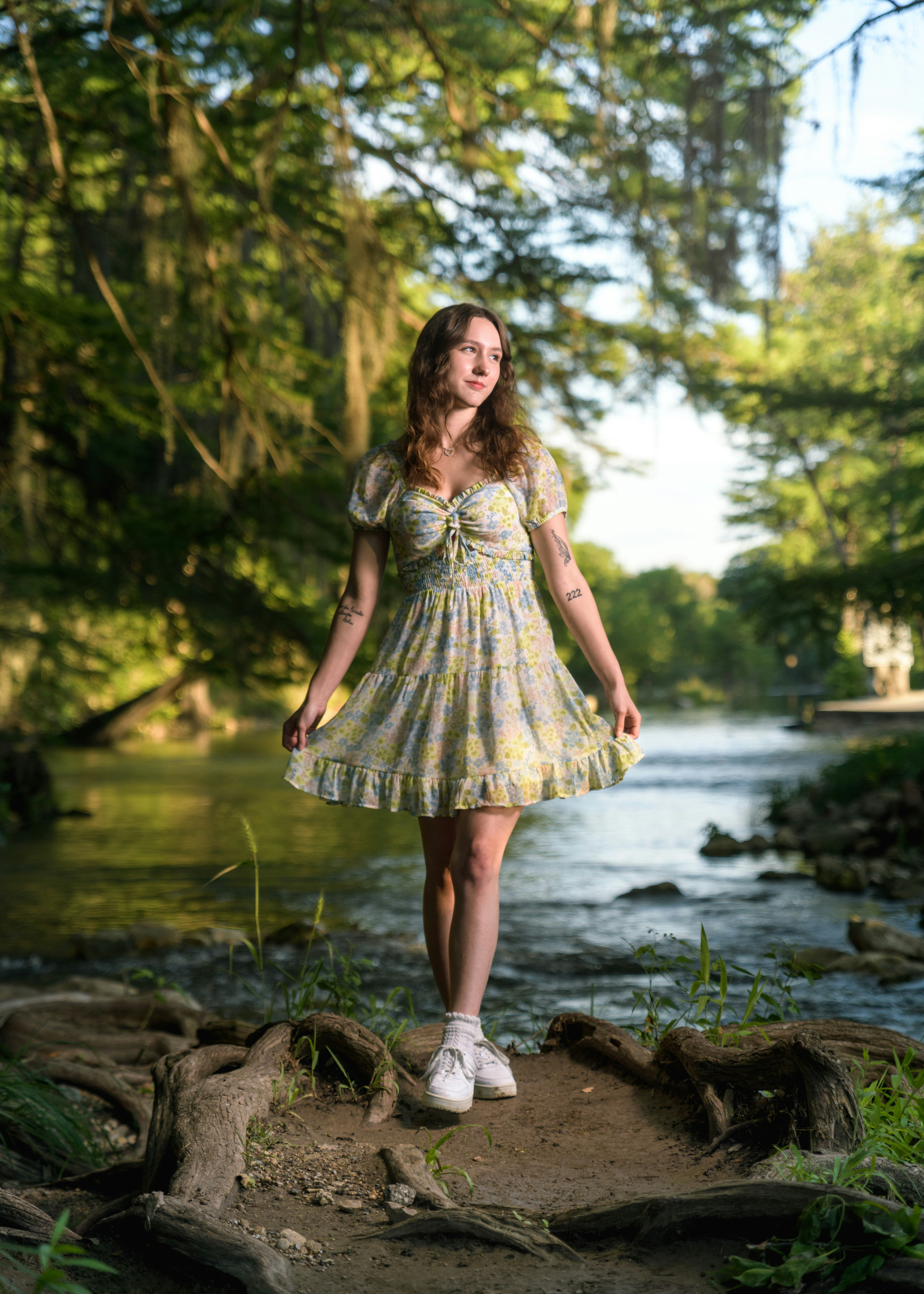 Sunlit Riverside Reverie: Floral Dress Portrait by a Quiet Forest Stream