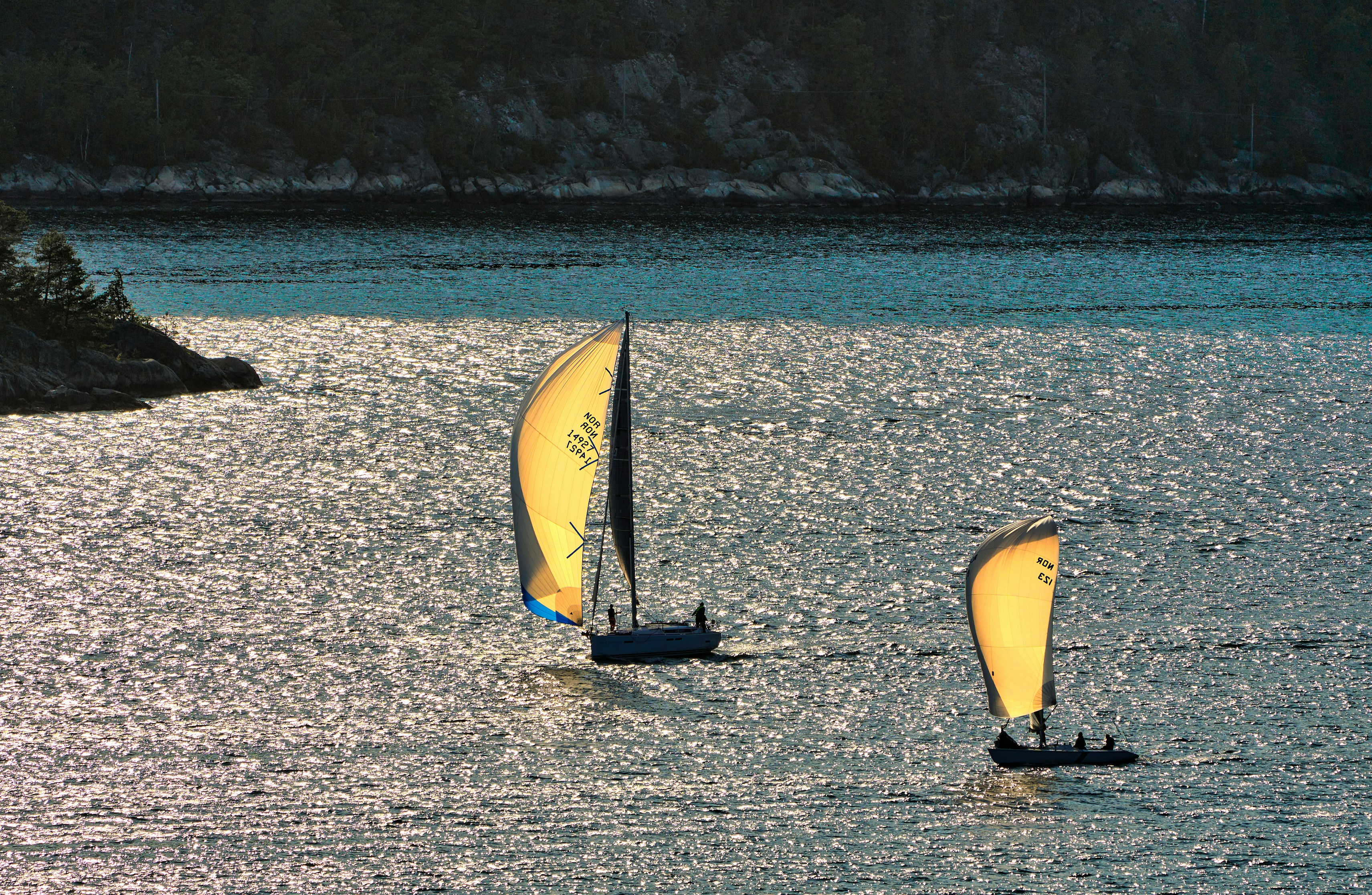 A couple of sail boats floating on top of a lake photo – Free ...